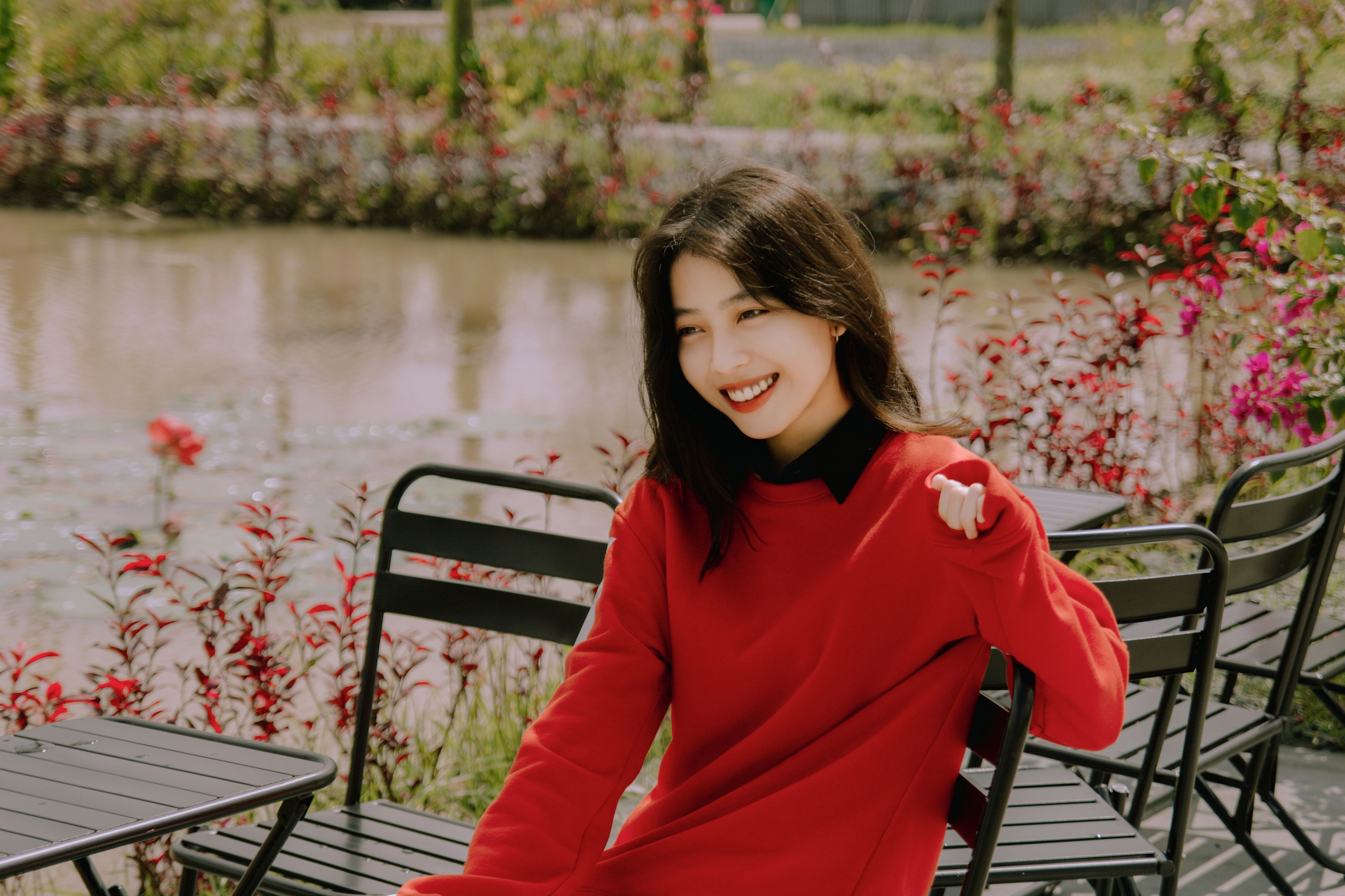 Woman Wearing Red Sweater Sitting by the Lake · Free Stock Photo