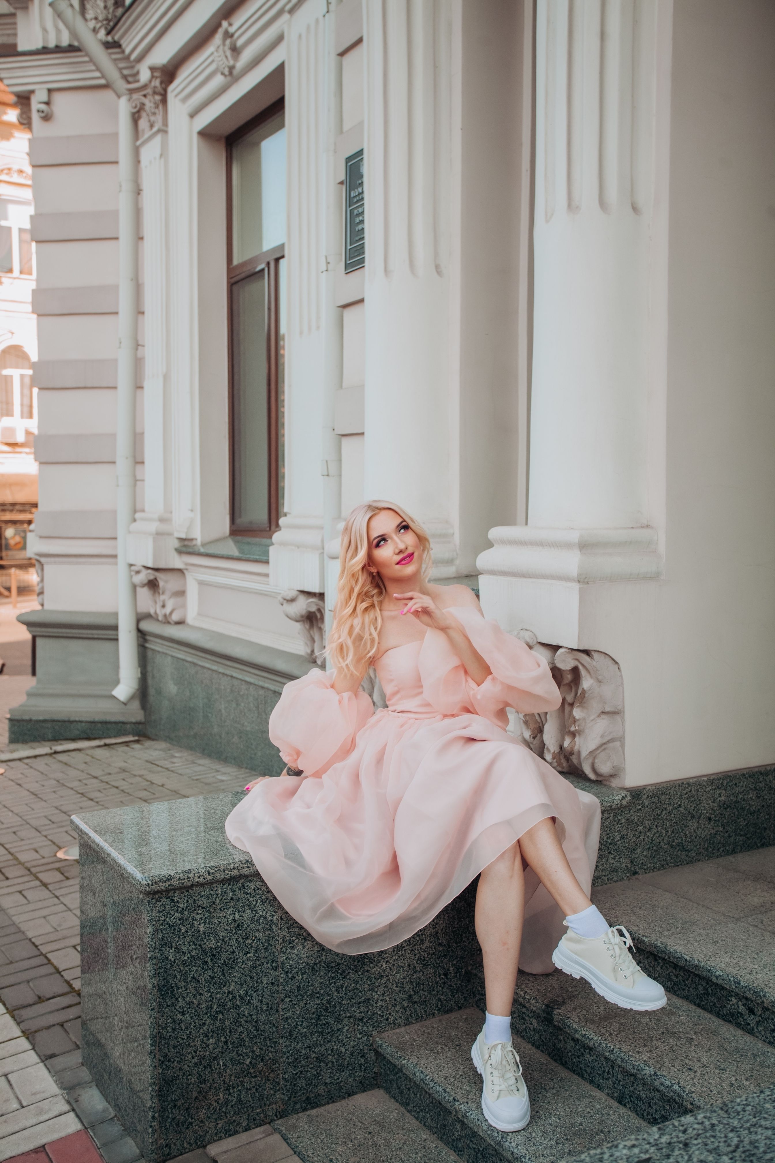 A woman in a pink dress sitting on steps · Free Stock Photo