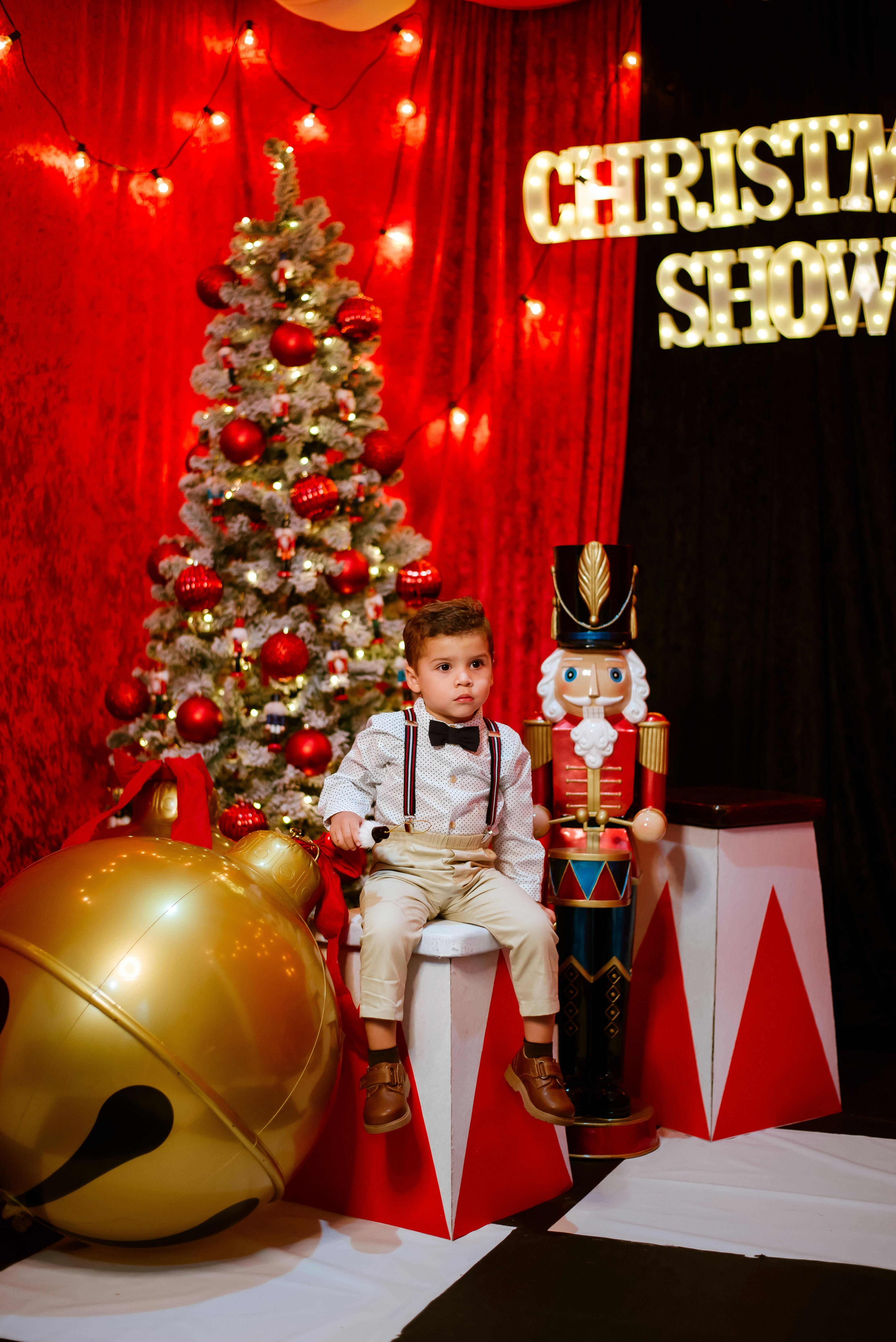 Little Boy Sitting on a Trapeze Between a Nutcracker Statue and a Large ...