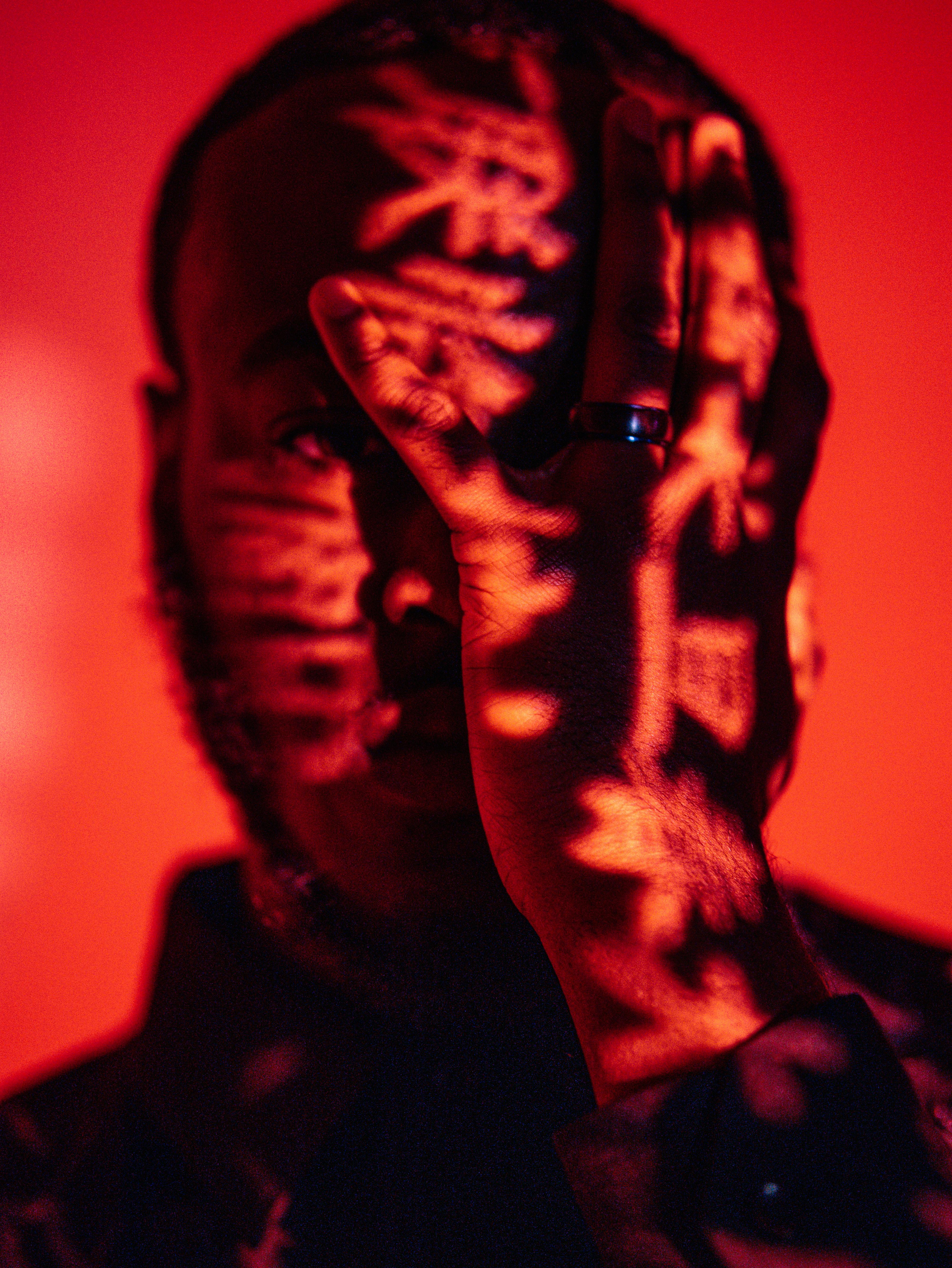 Portrait of a Man Posing in Studio in Red Lighting with Projections ...