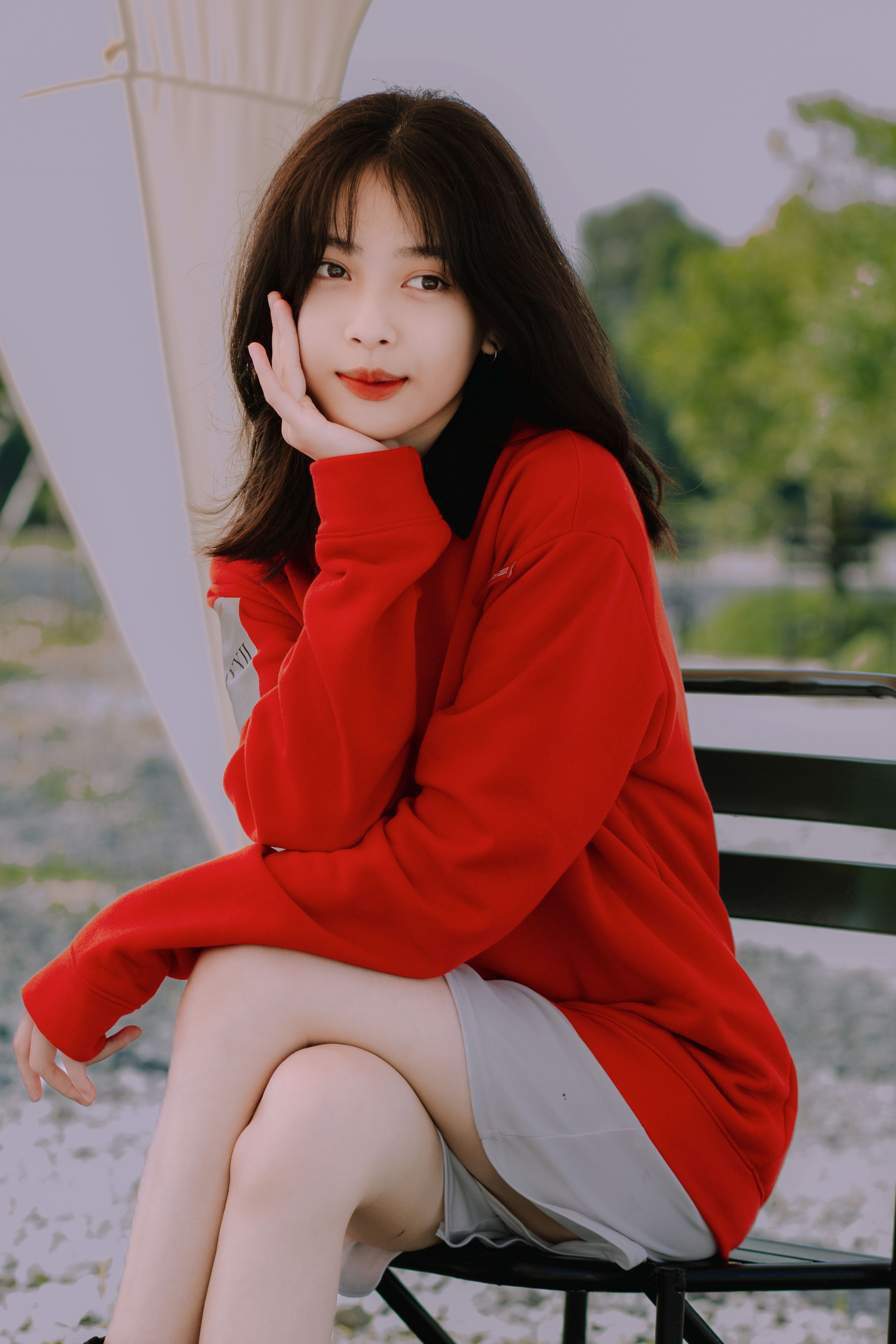 Woman Wearing Red Cardigan Sitting on Bench · Free Stock Photo