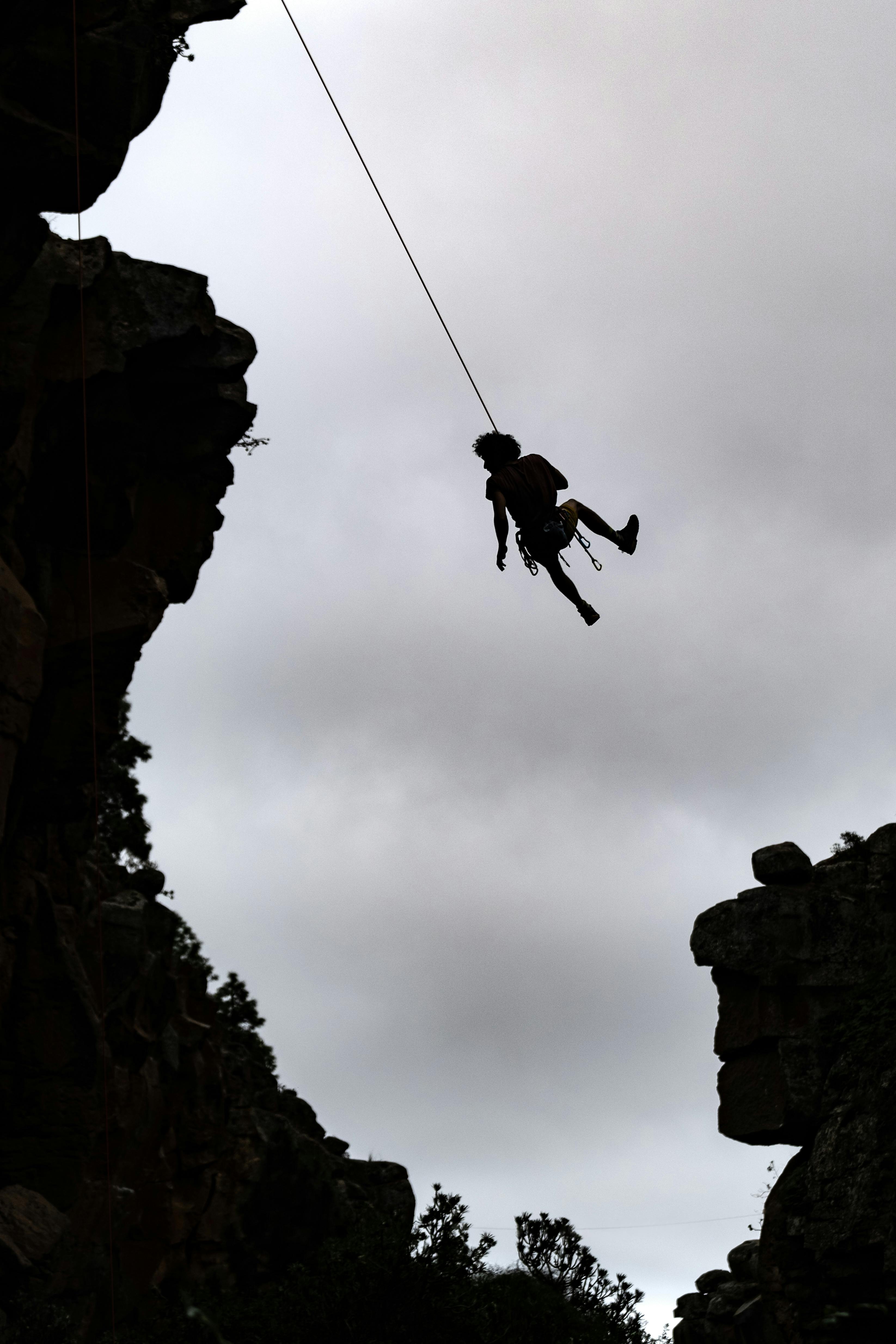 Silhouette of Man Walking Between Two Cliff · Free Stock Photo