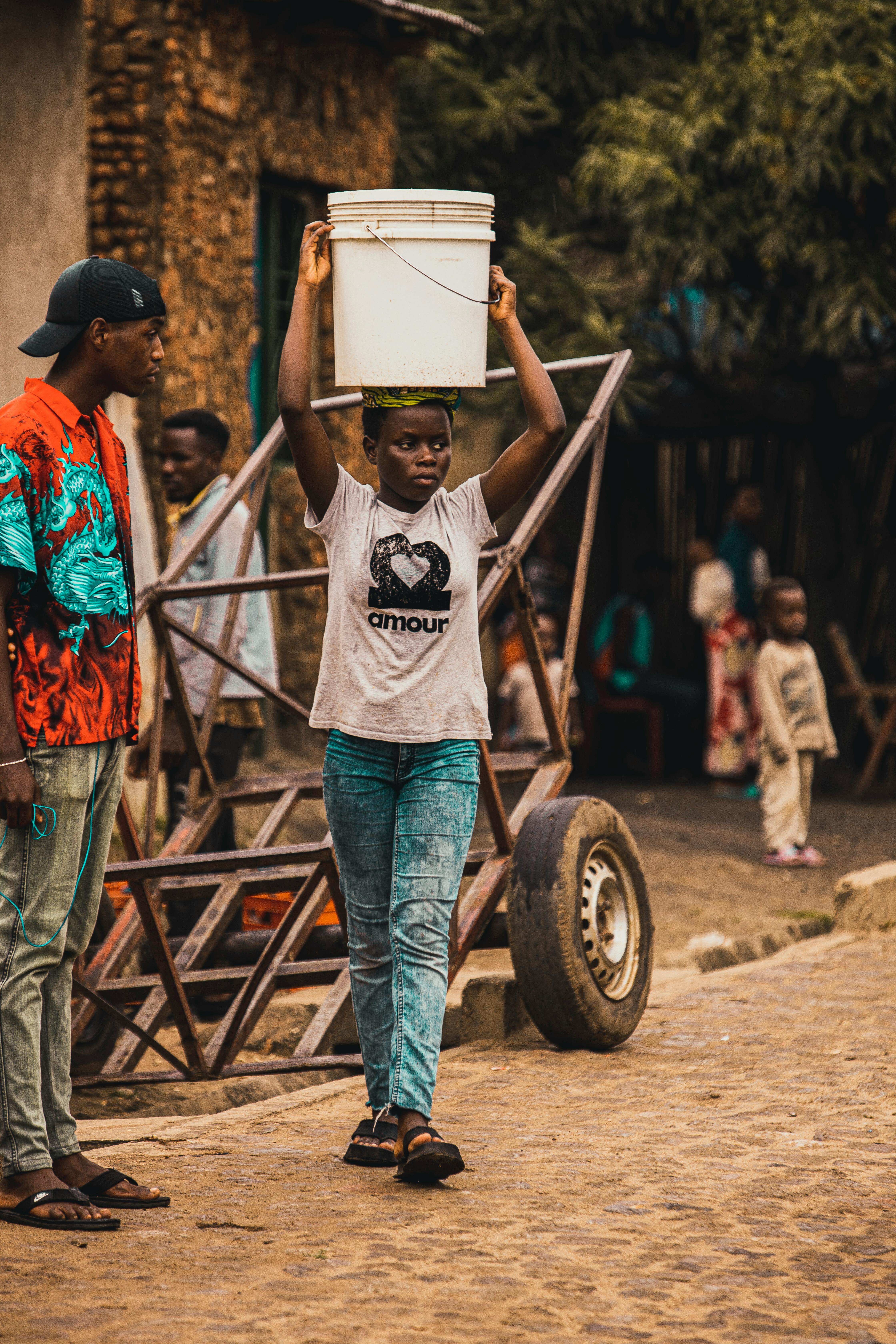 Boy Carrying Bucket on Head · Free Stock Photo