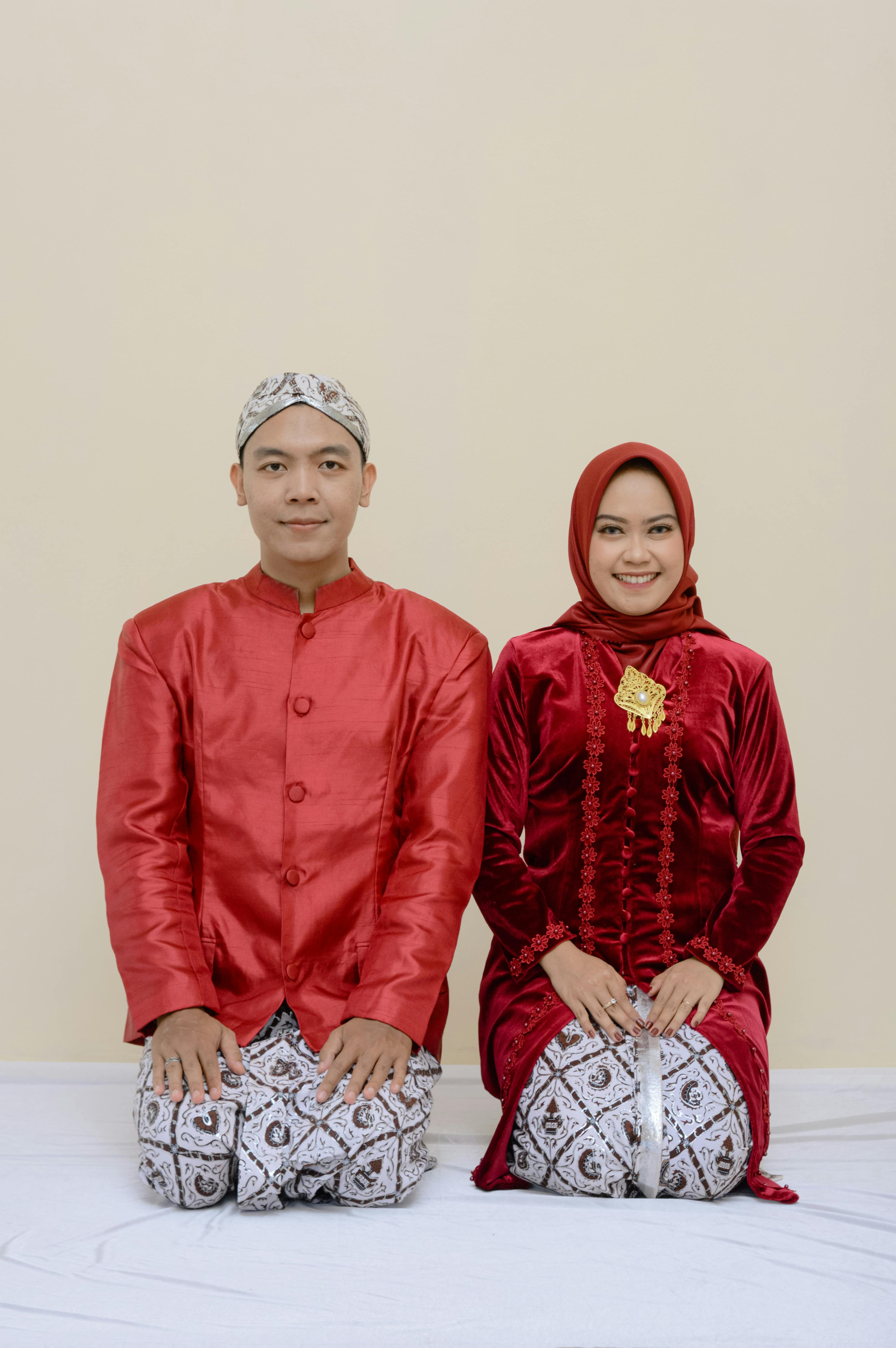Couple Sitting in Red, Traditional Clothing · Free Stock Photo