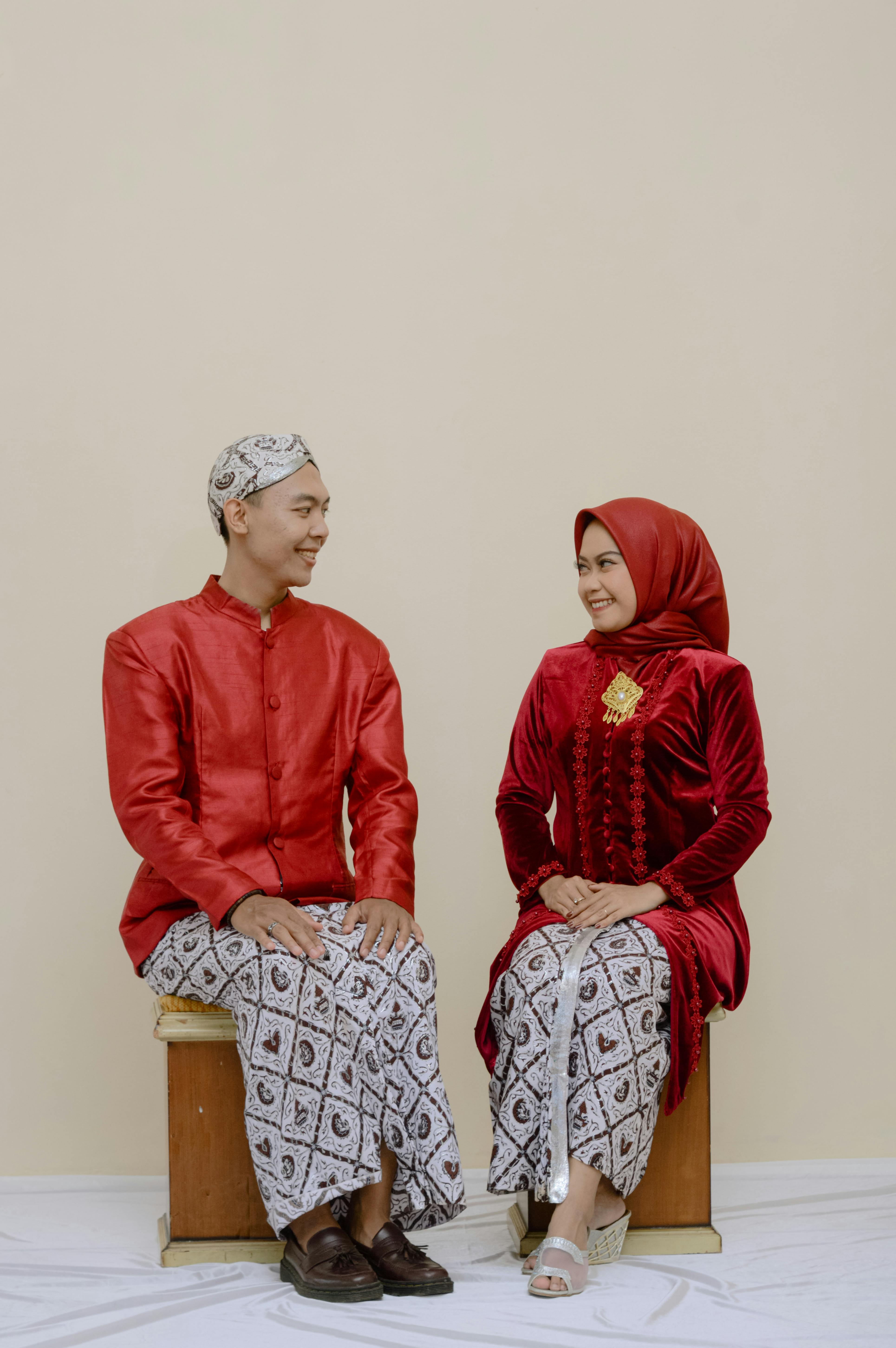 Smiling Woman and Man Sitting in Red, Traditional Clothing · Free Stock ...