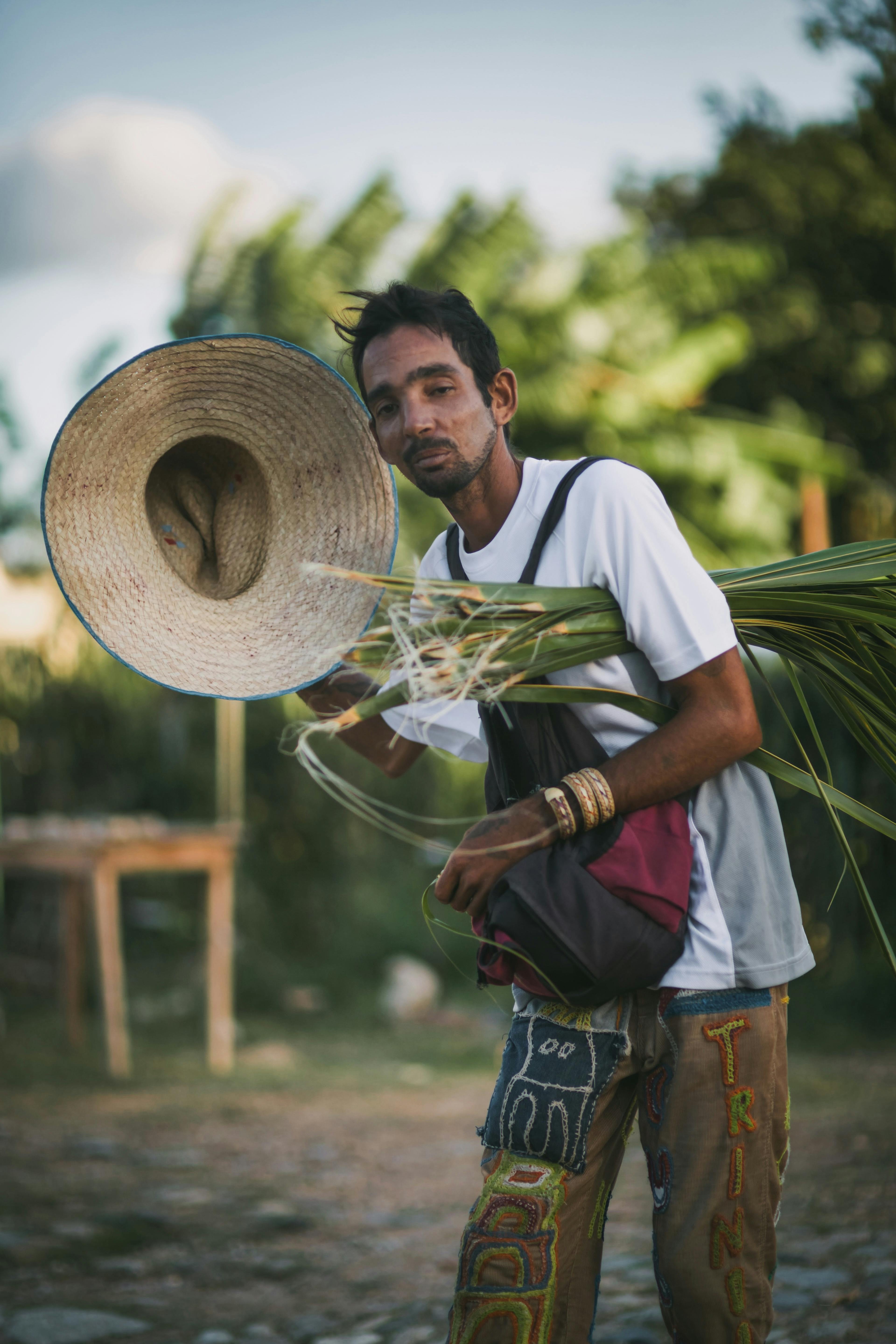 Man Holding a Hat and Working in the Field · Free Stock Photo