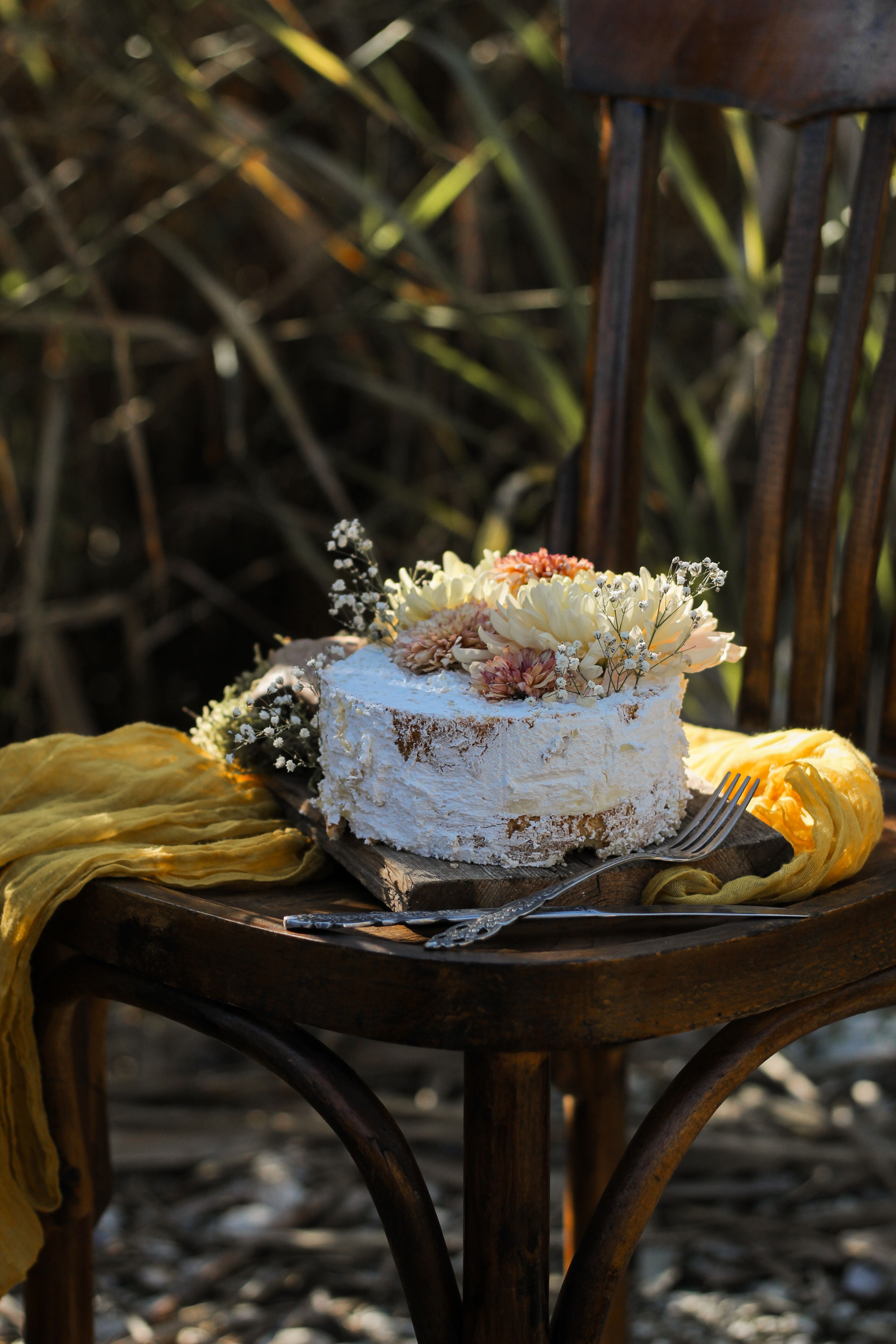 A Cake with Rustic Decoration Standing on a Chair Outside · Free Stock ...