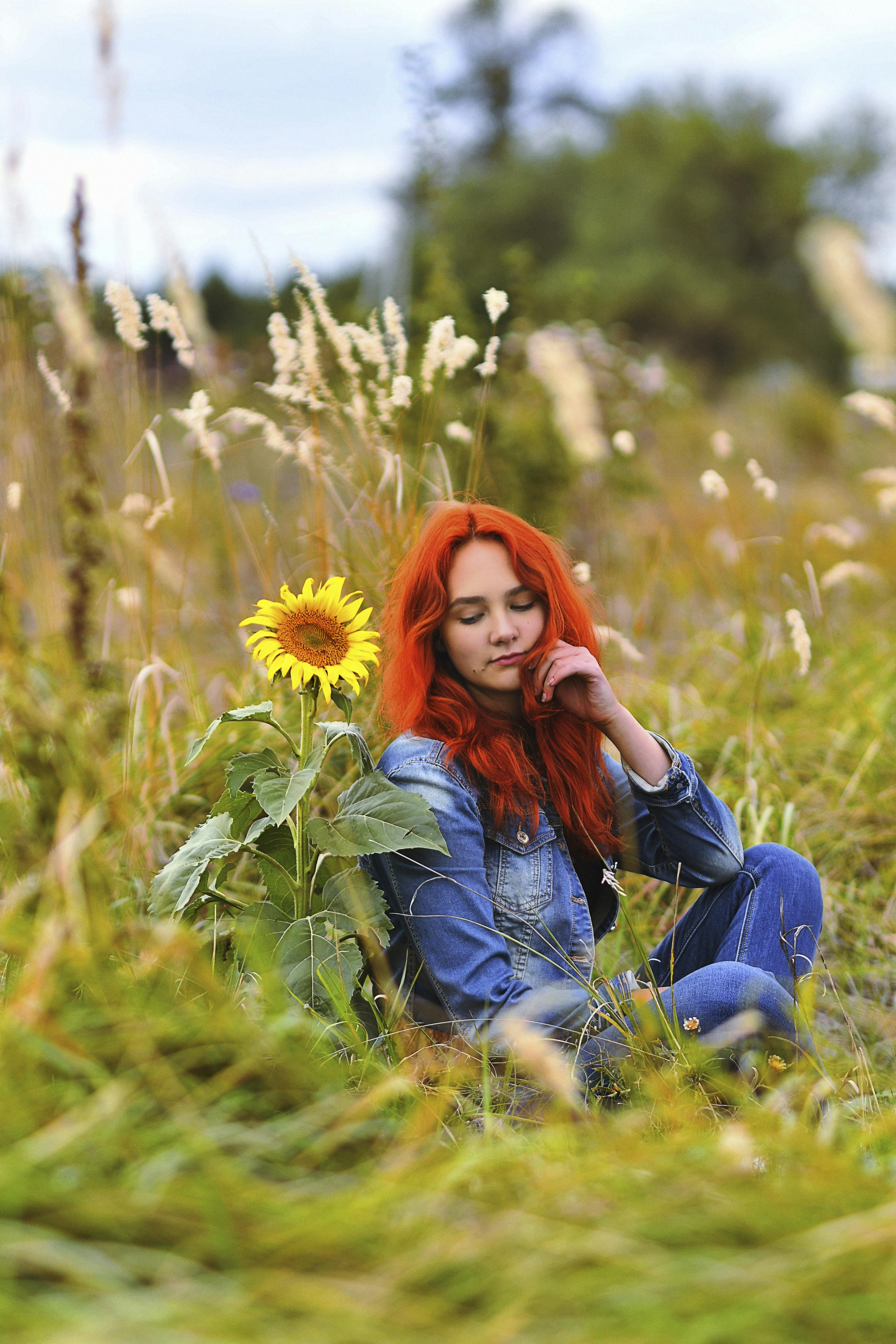 Photo of a Redhead Woman Wearing Jeans, Sitting in Meadow by a ...