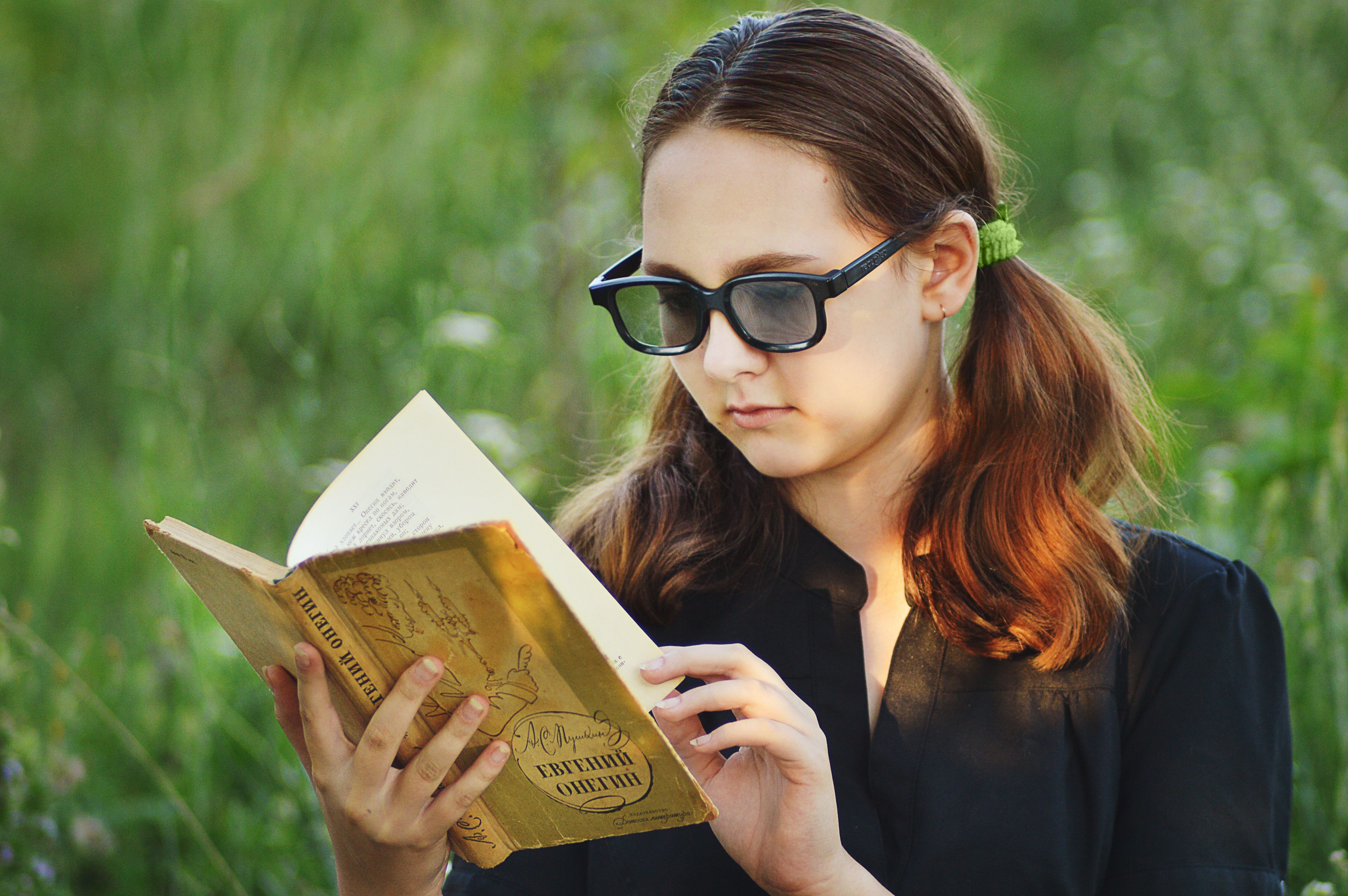 Photo of a Girl with Pigtails, Reading a Book on a Grass Field · Free ...