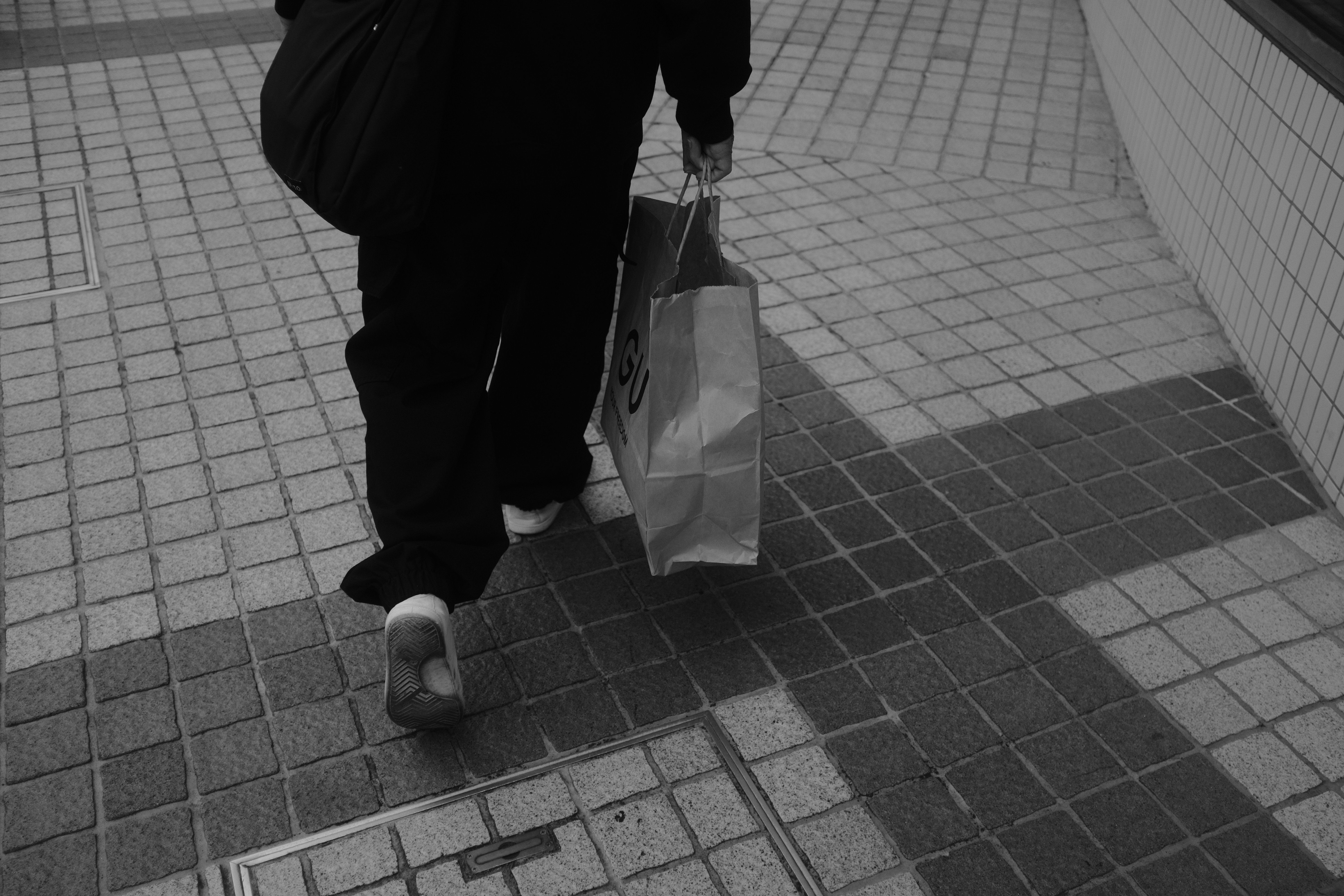 Person Walking with a Shopping Bag on the Sidewalk · Free Stock Photo
