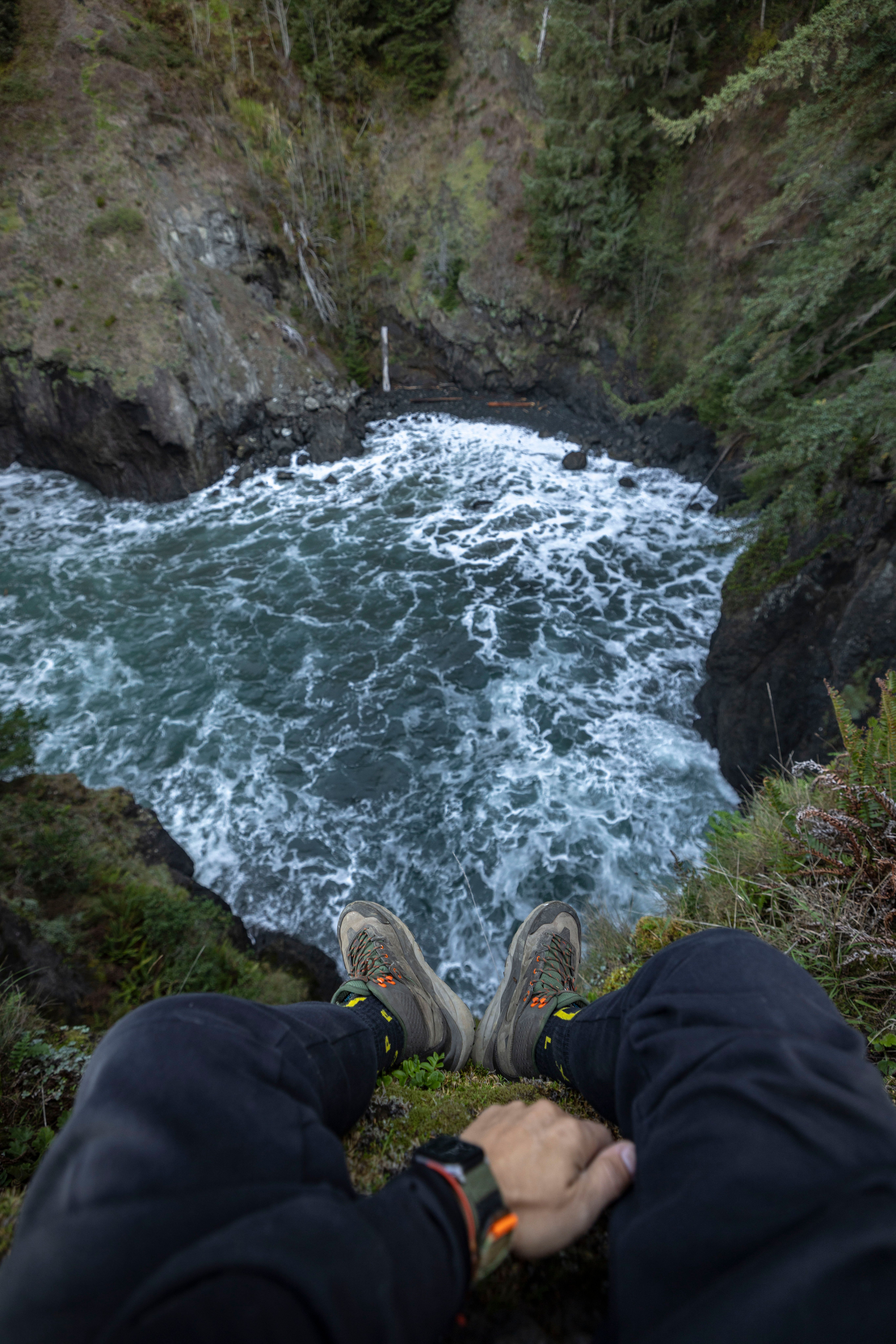 Legs of Person Sitting on Edge over Water · Free Stock Photo