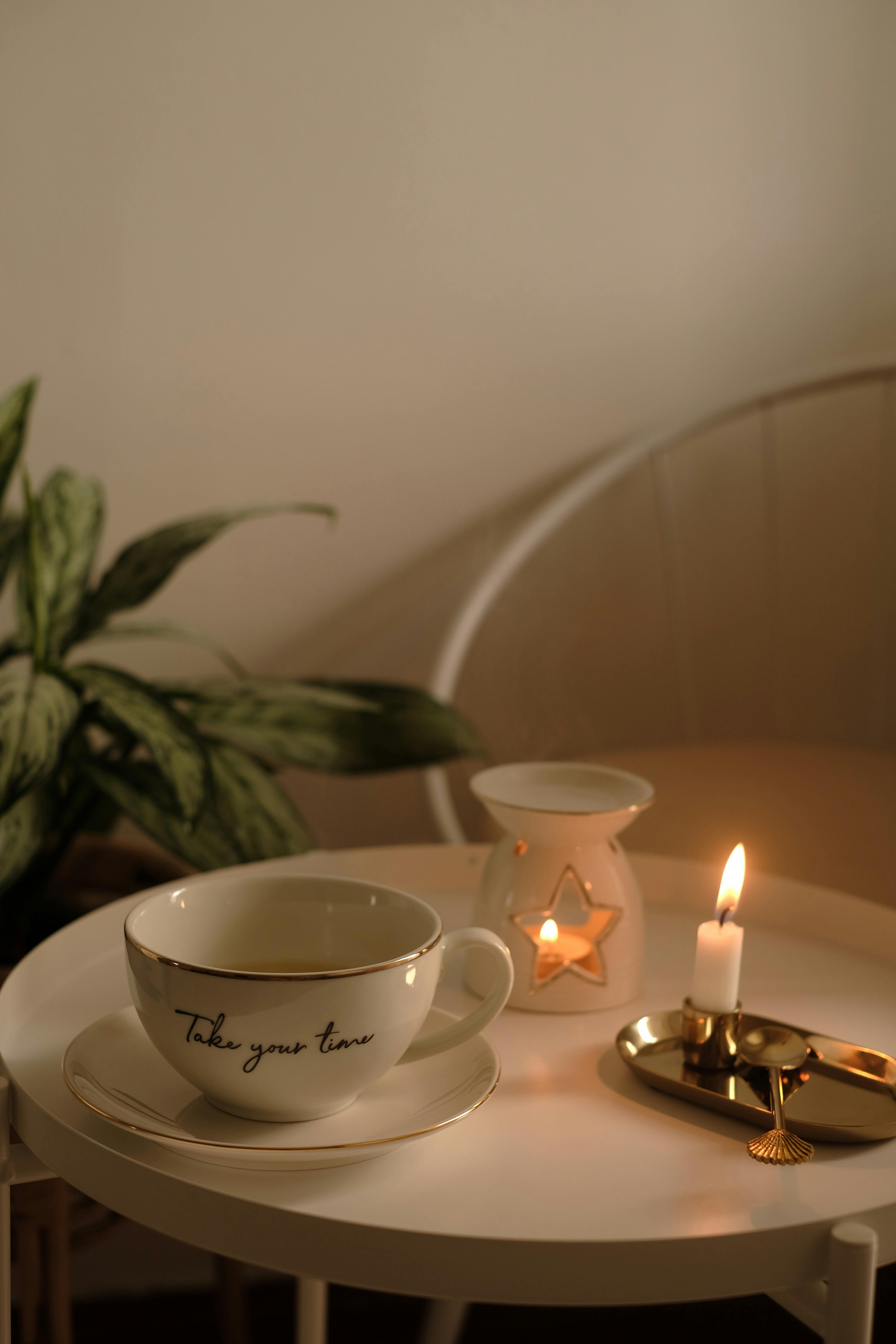 Porcelain Tea Cup and a Candle on a Table · Free Stock Photo