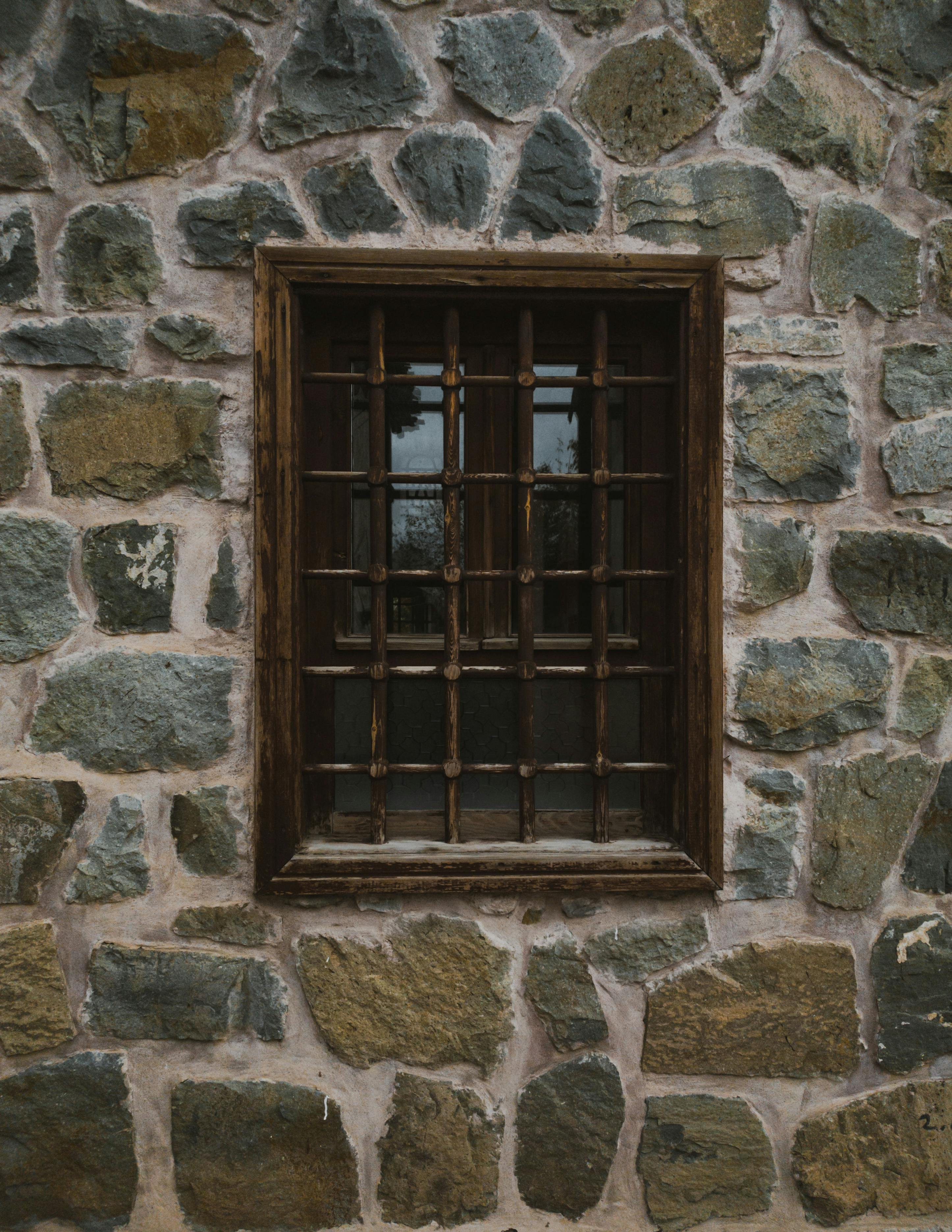 Folding Bicycle Under a Barred Window · Free Stock Photo