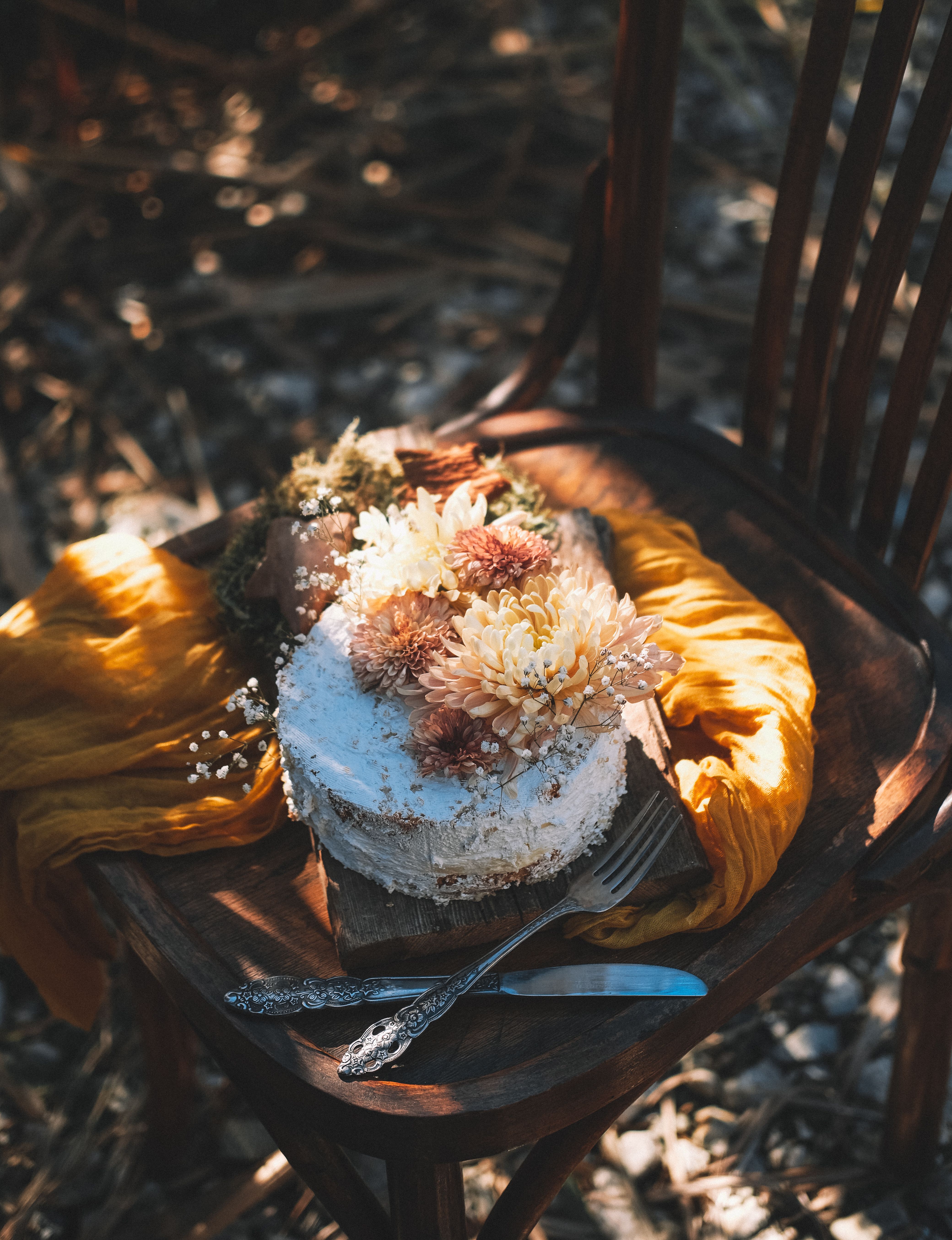 A Cake with Rustic Decorations Standing on a Wooden Chair Outside ...