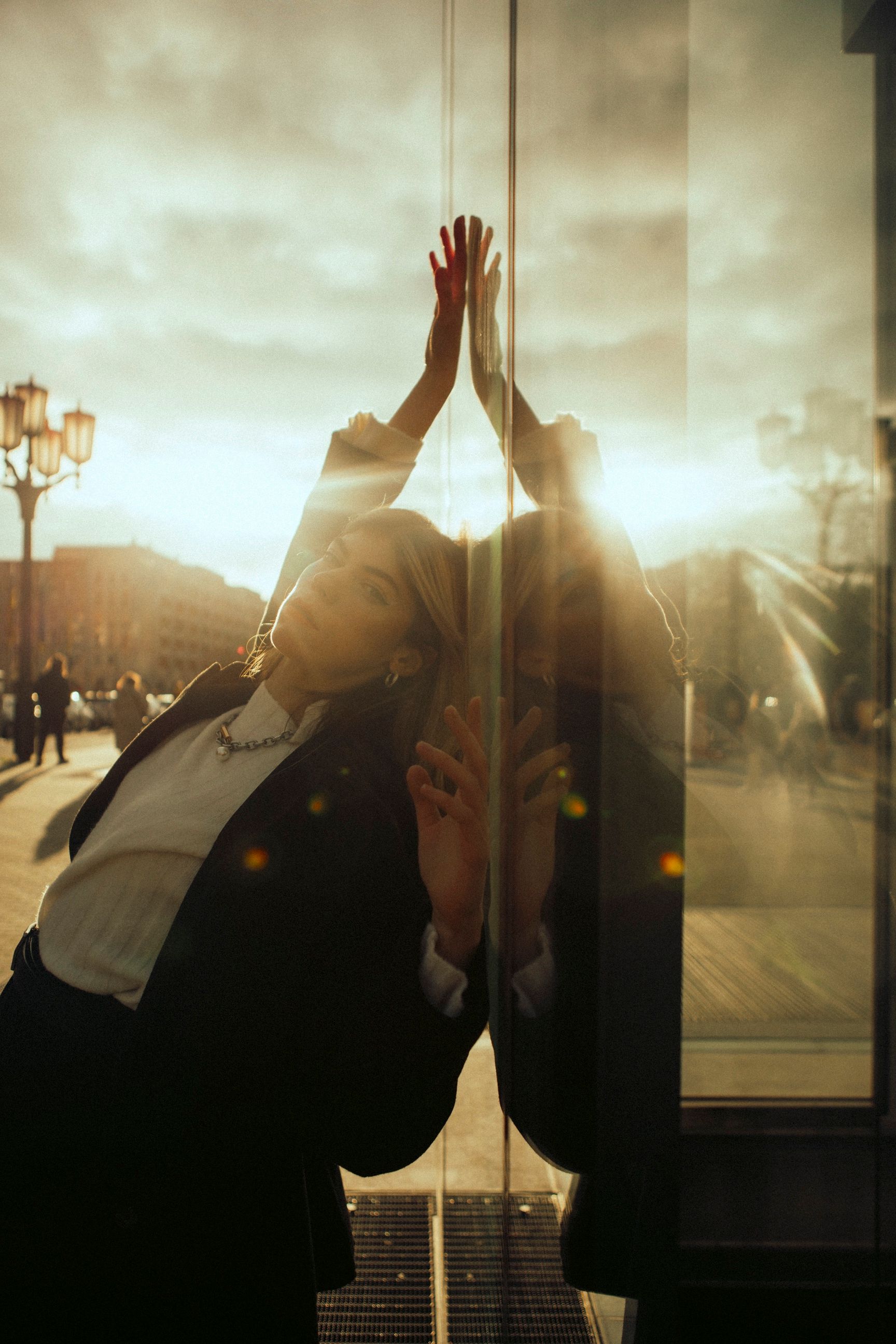 A woman is leaning against a glass window · Free Stock Photo