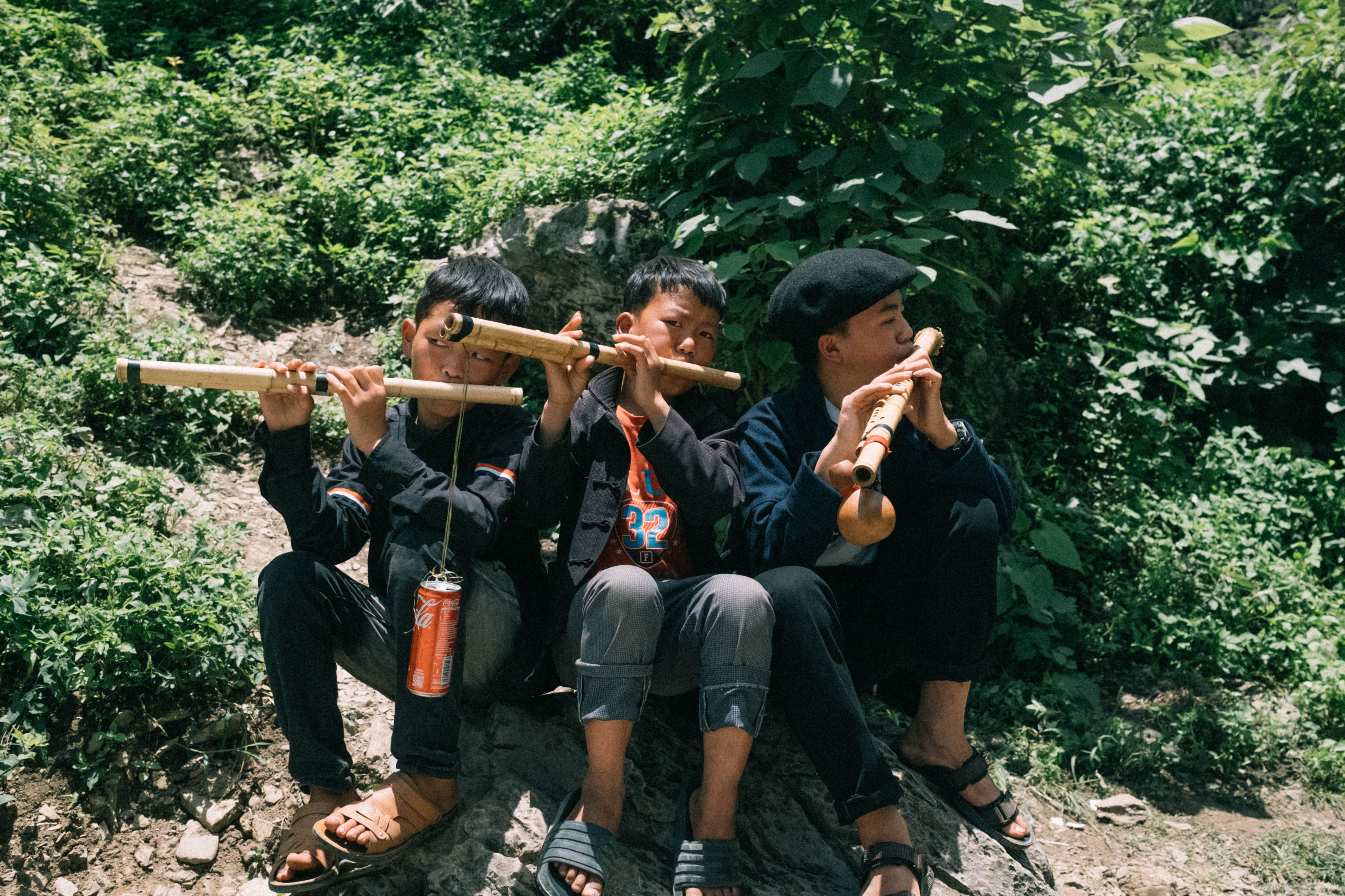 A Group of Boys Sitting Outside and Playing Flutes · Free Stock Photo
