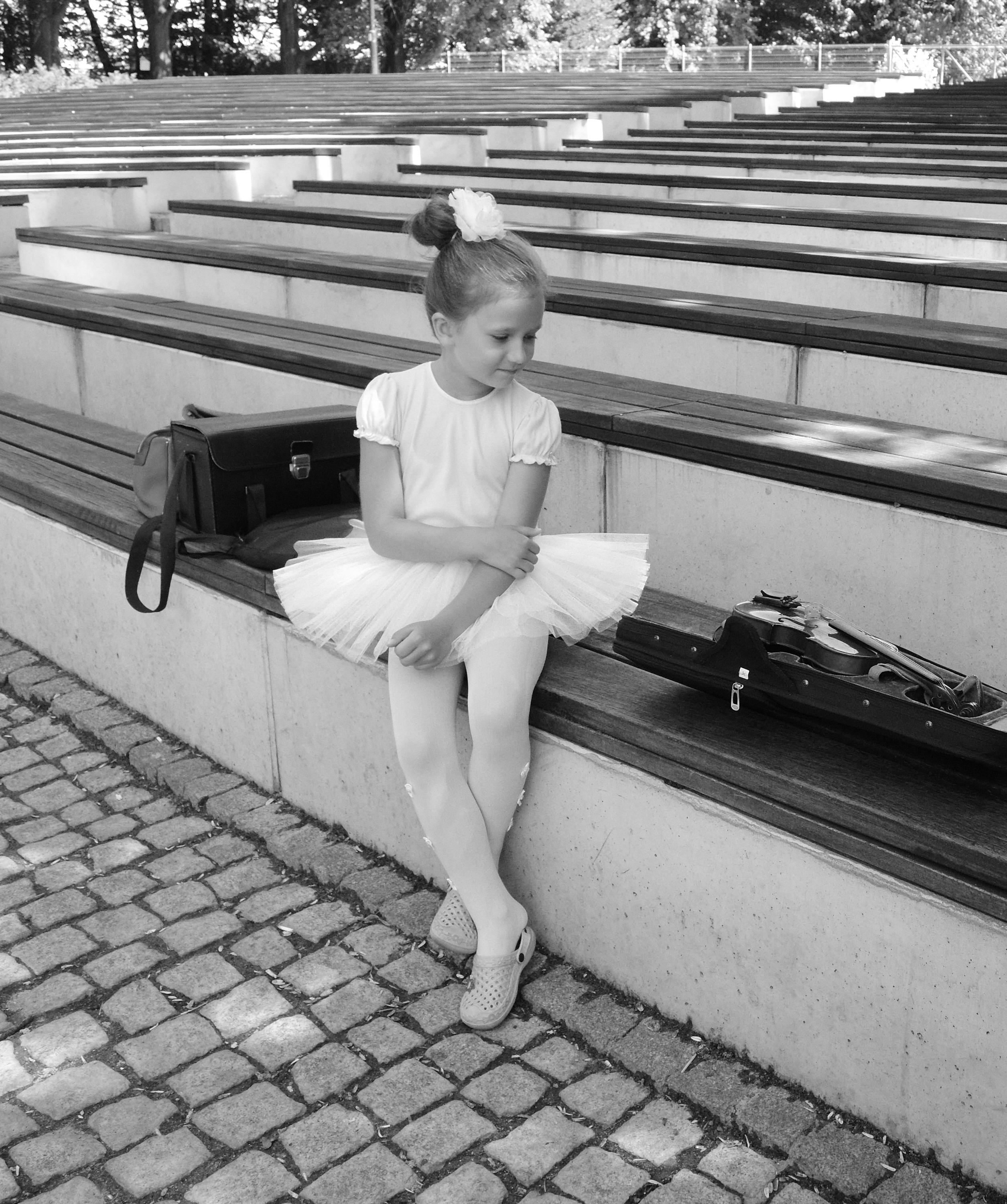A little girl in a tutu sitting on a bench · Free Stock Photo