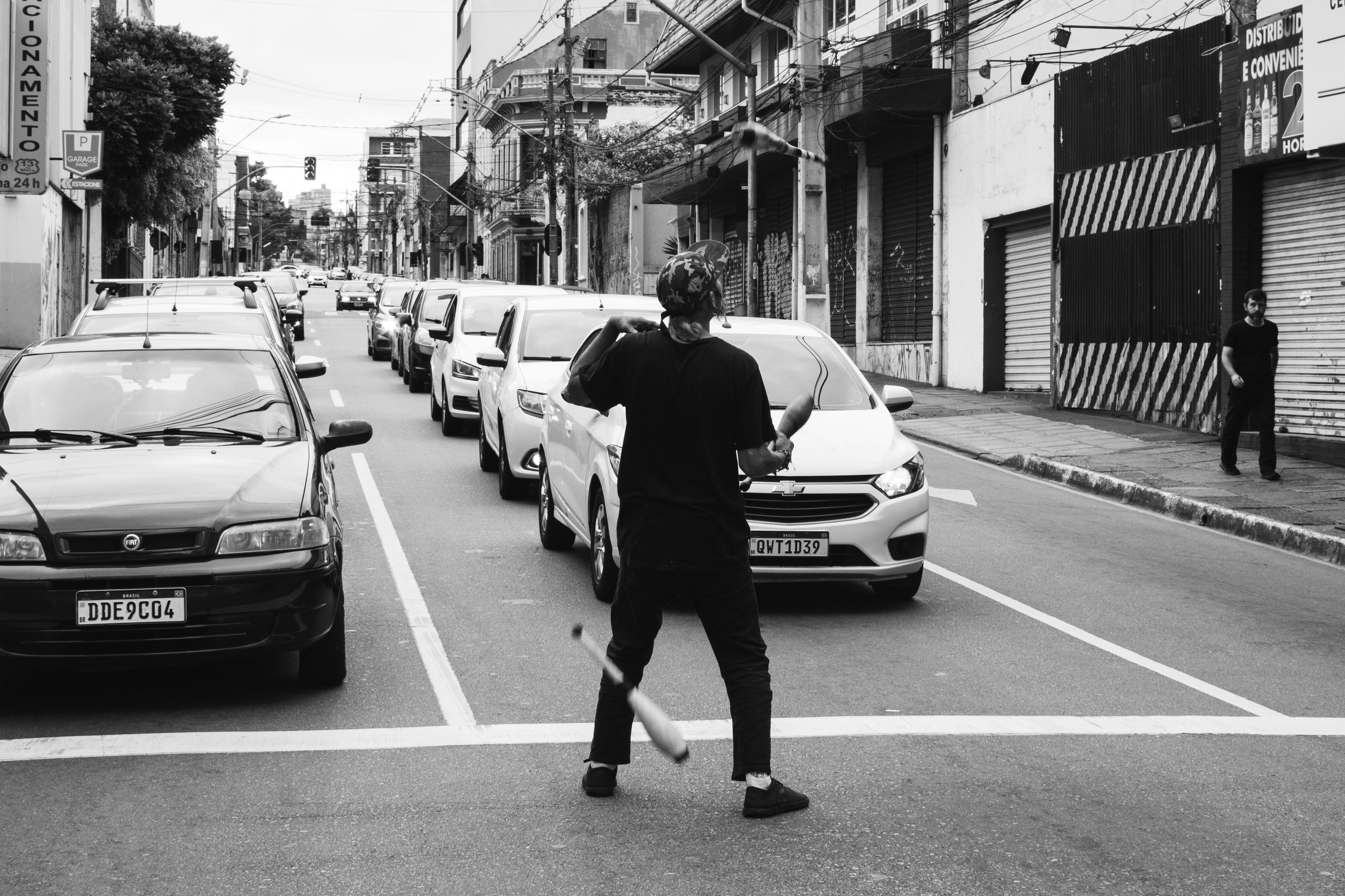 Man Juggling on the Street in front of Waiting Cars · Free Stock Photo