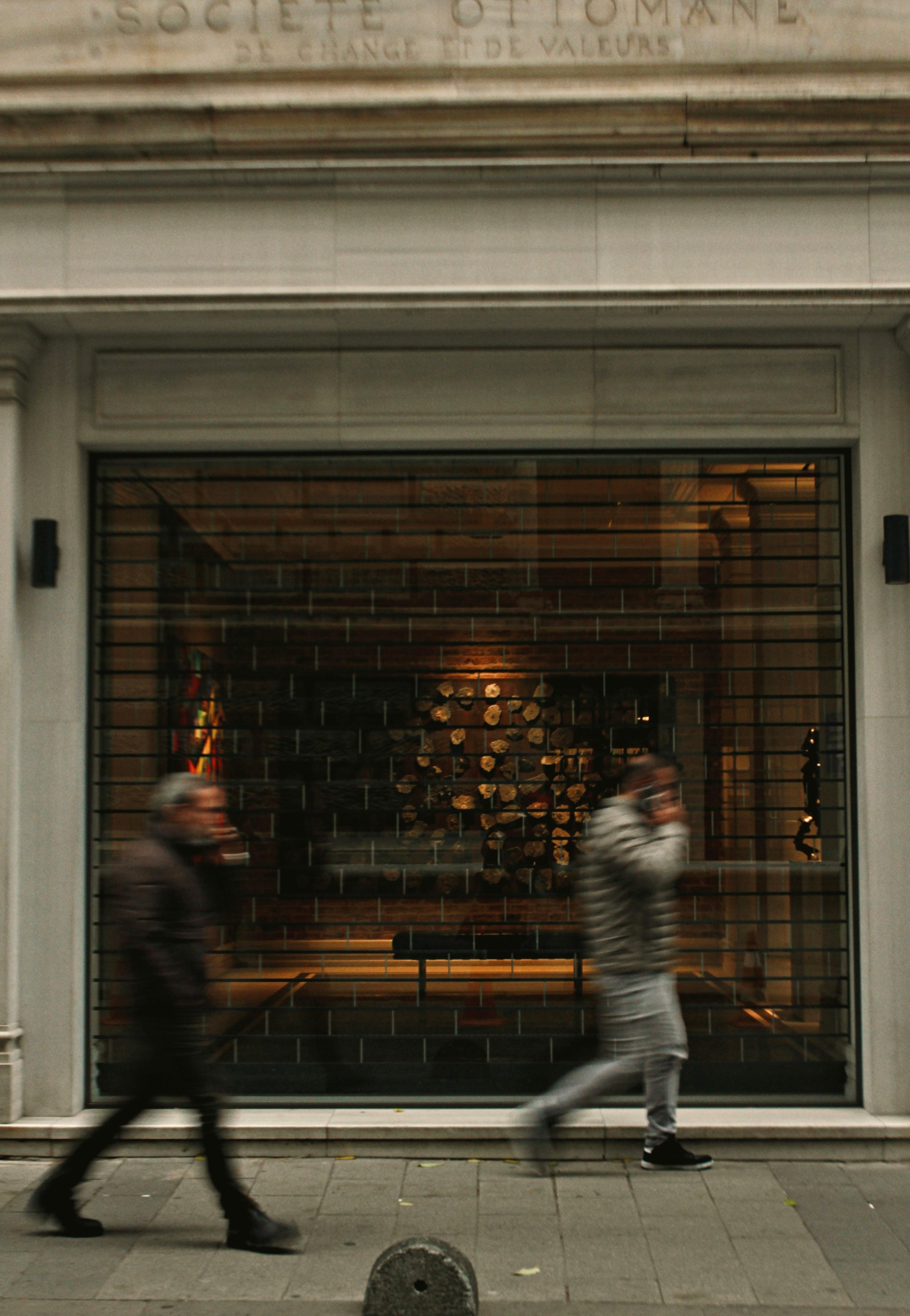Men Walking in Front of a Shop Window · Free Stock Photo