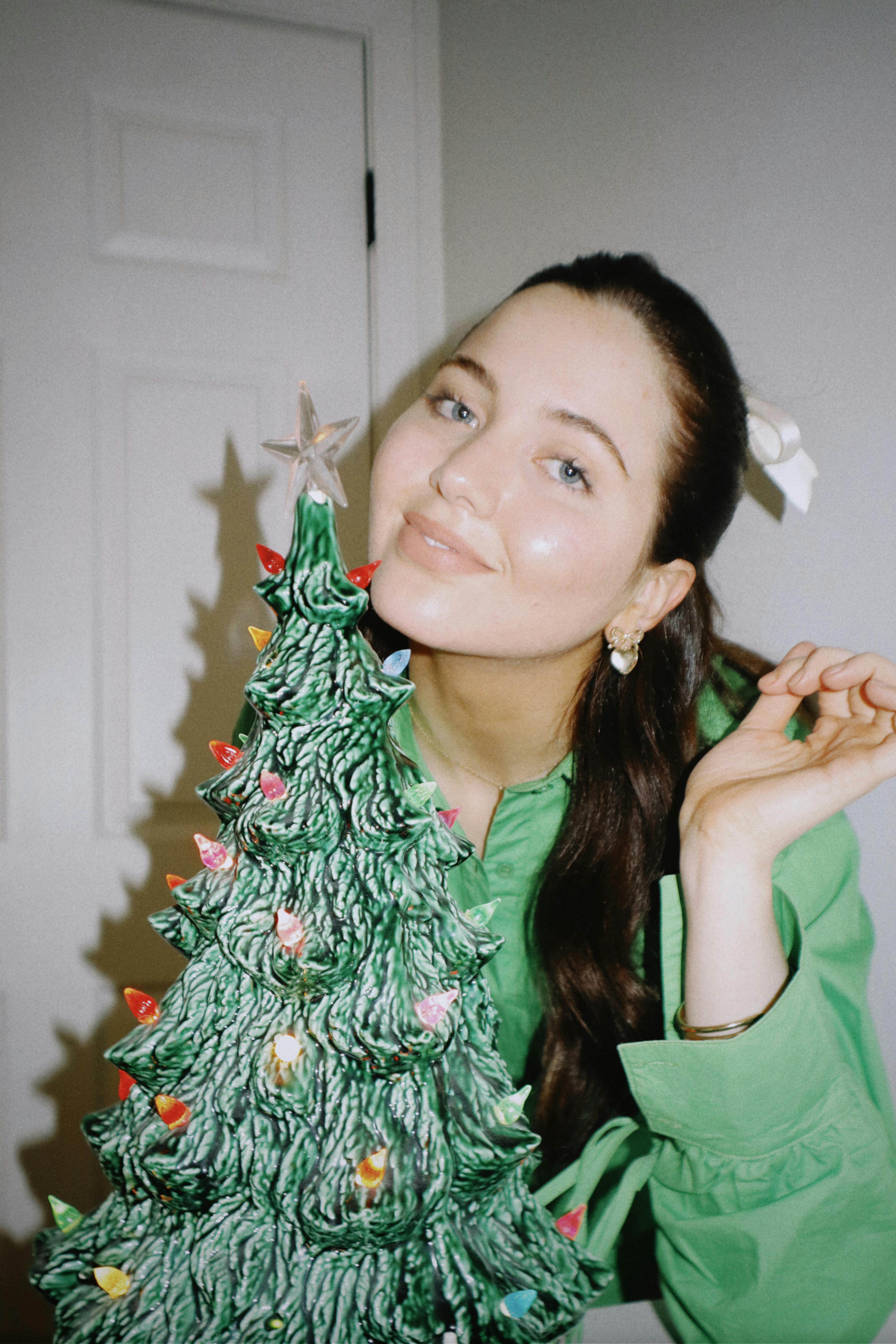 Serene Woman in Green Shirt by Christmas Tree · Free Stock Photo
