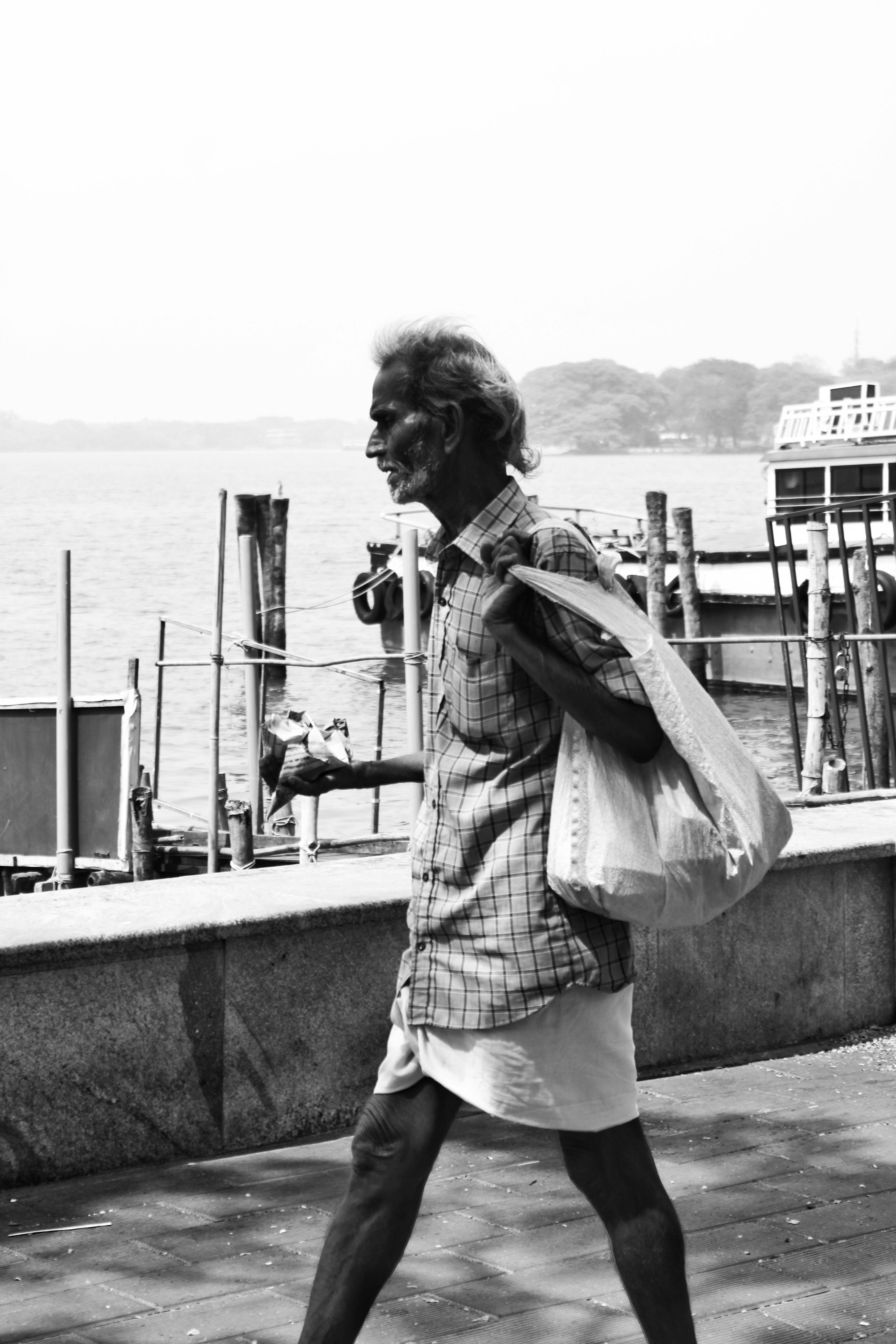 Black and White Photo of an Elderly Man Walking near a Body of Water ...