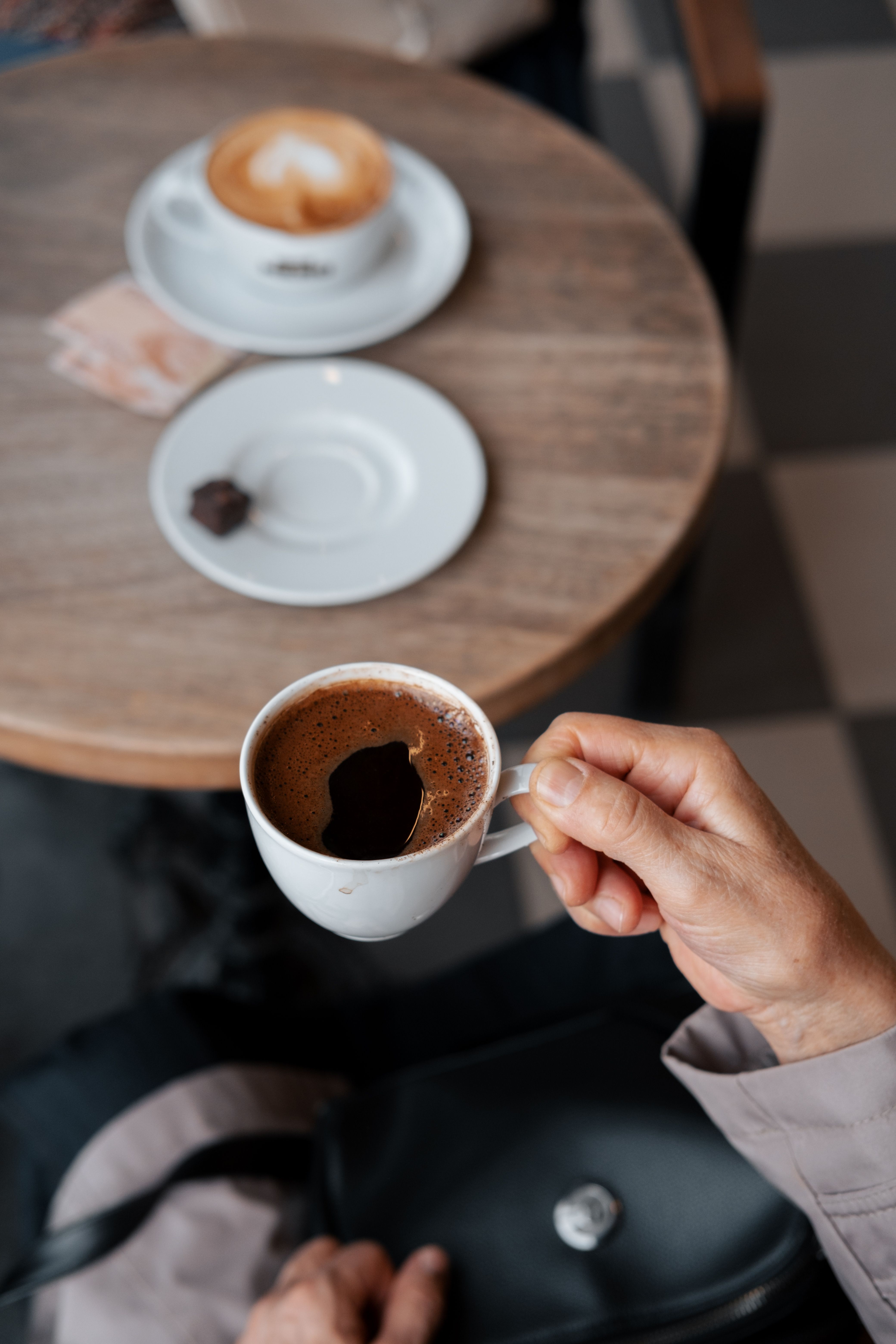 A Person Sitting and Drinking Coffee in a Cafe · Free Stock Photo