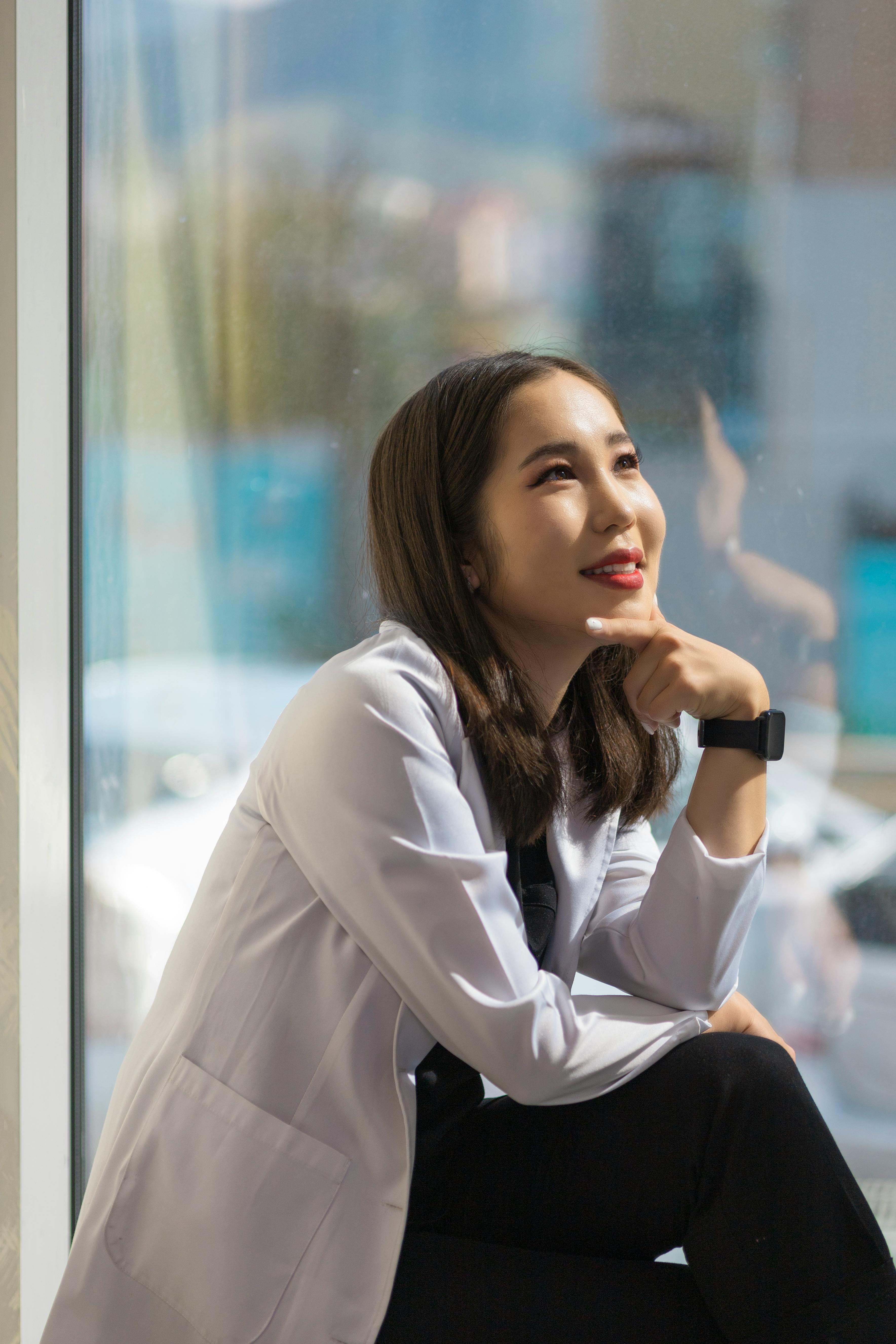 Young Elegant Woman Sitting Outside by the Window and Smiling · Free ...
