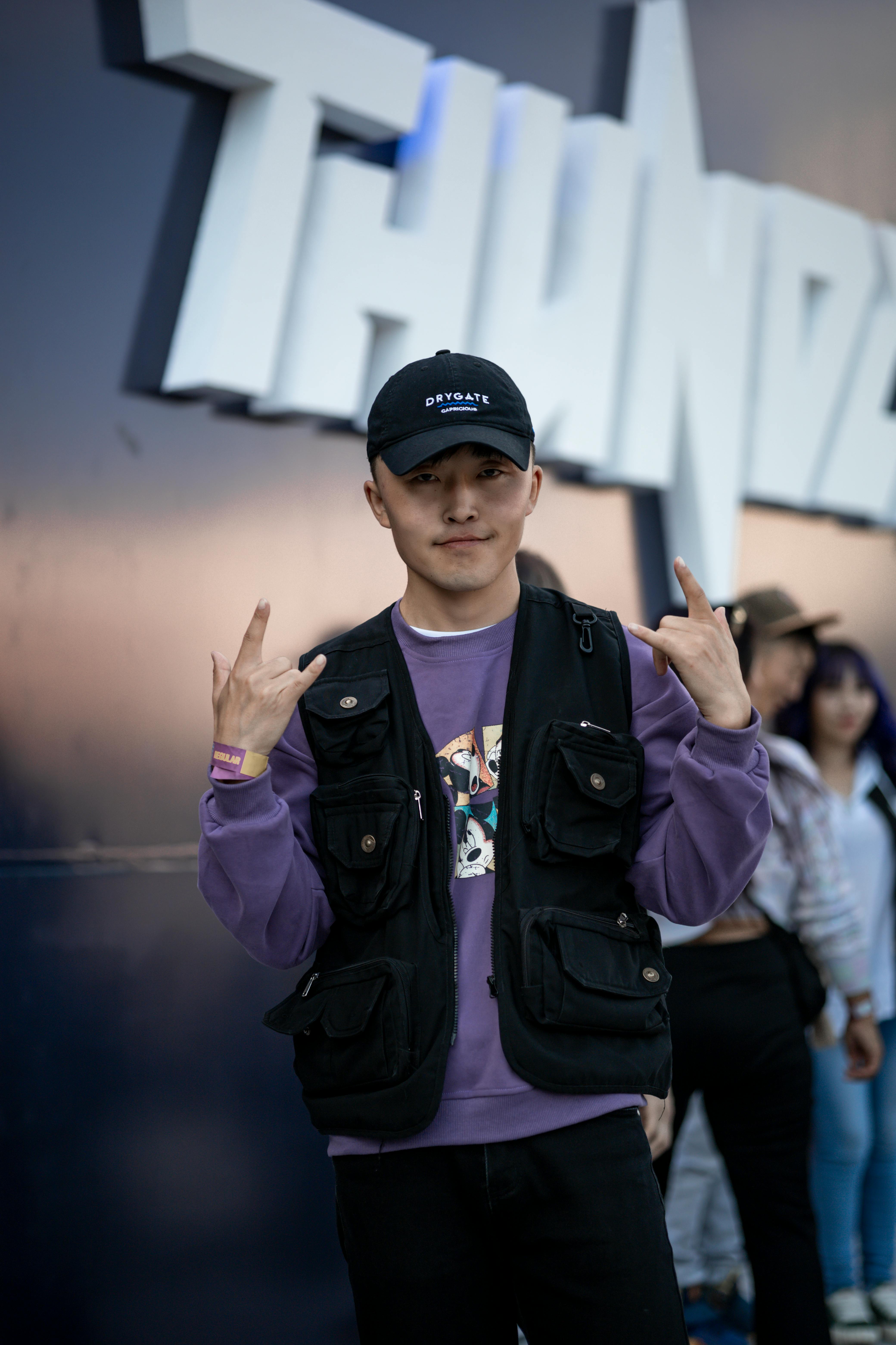 Photo of a Young Man Gesturing, and a Logo in Background · Free Stock Photo