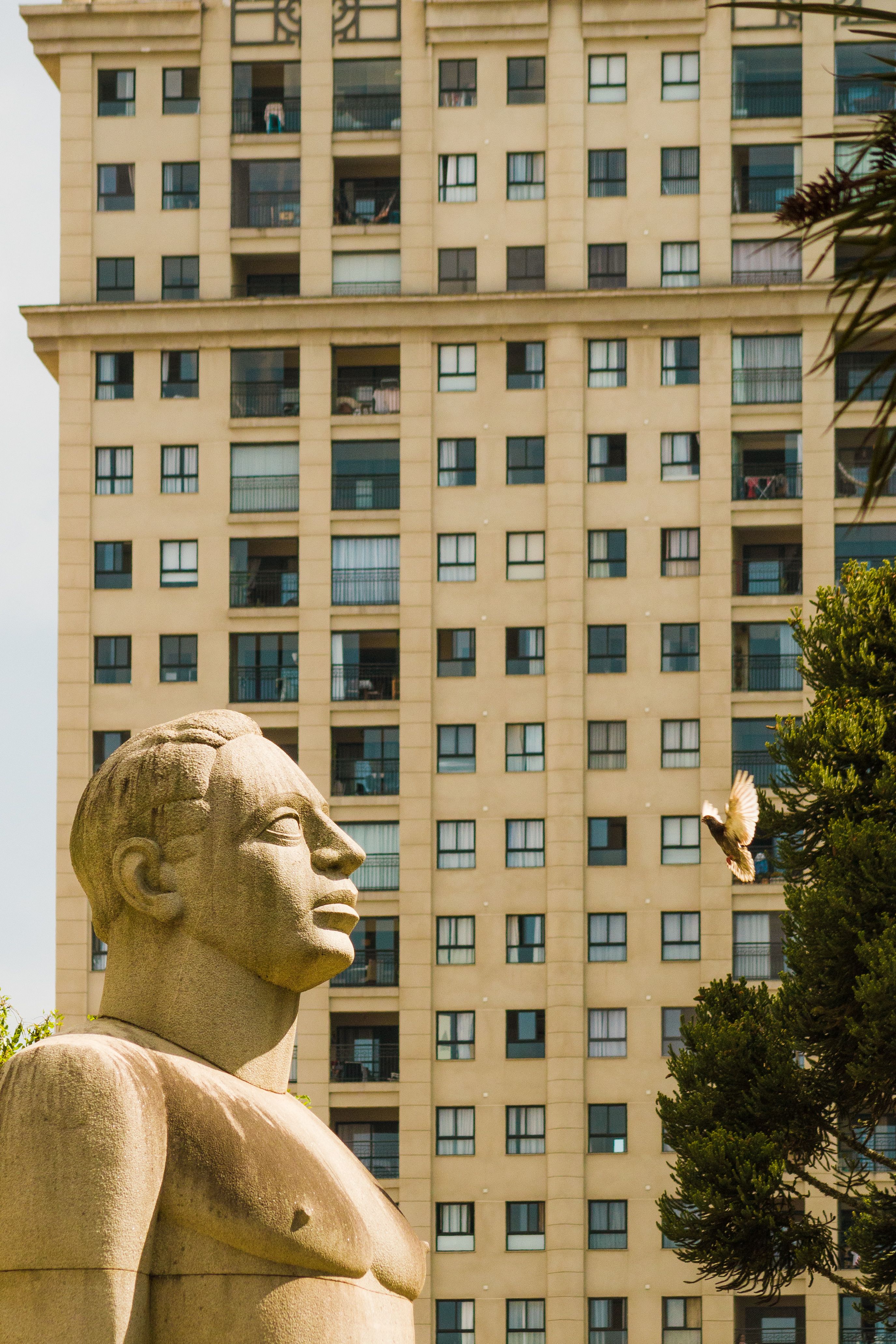Huge Statue of Man with Building behind · Free Stock Photo