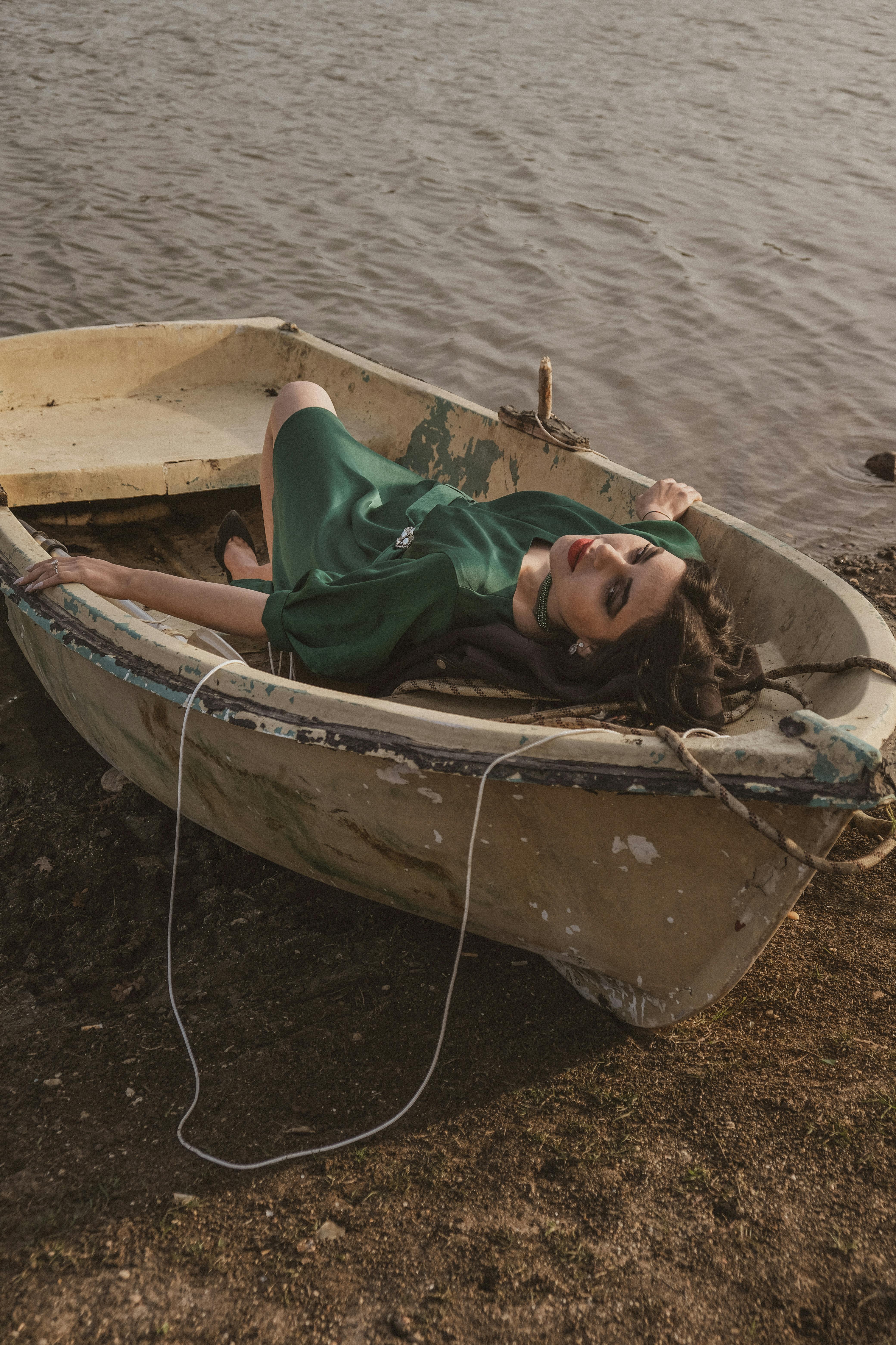 Woman Lying Down in Abandoned Boat on Lakeshore · Free Stock Photo