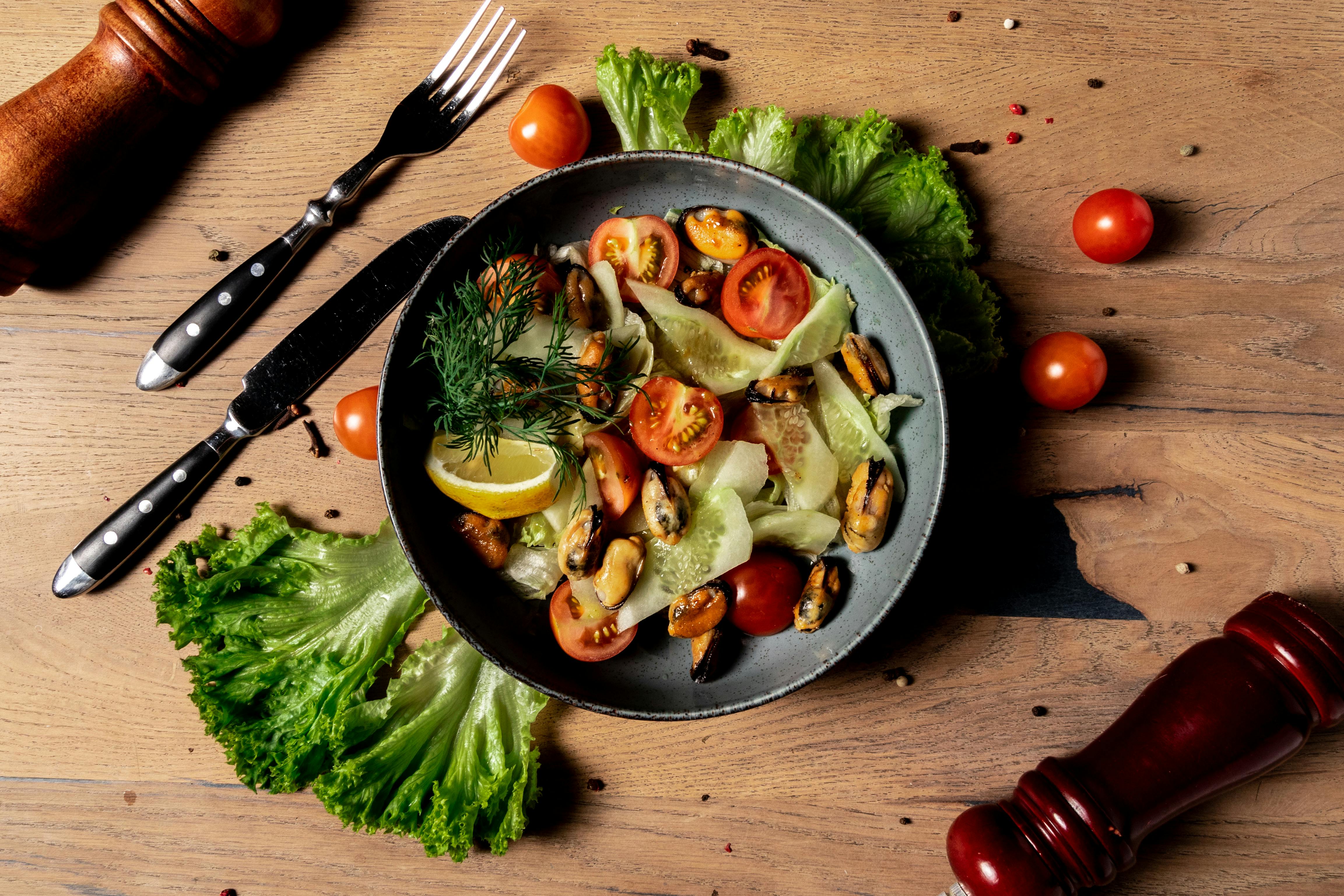 A Salad in a Bowl with Ingredients Scattered around the Table · Free ...