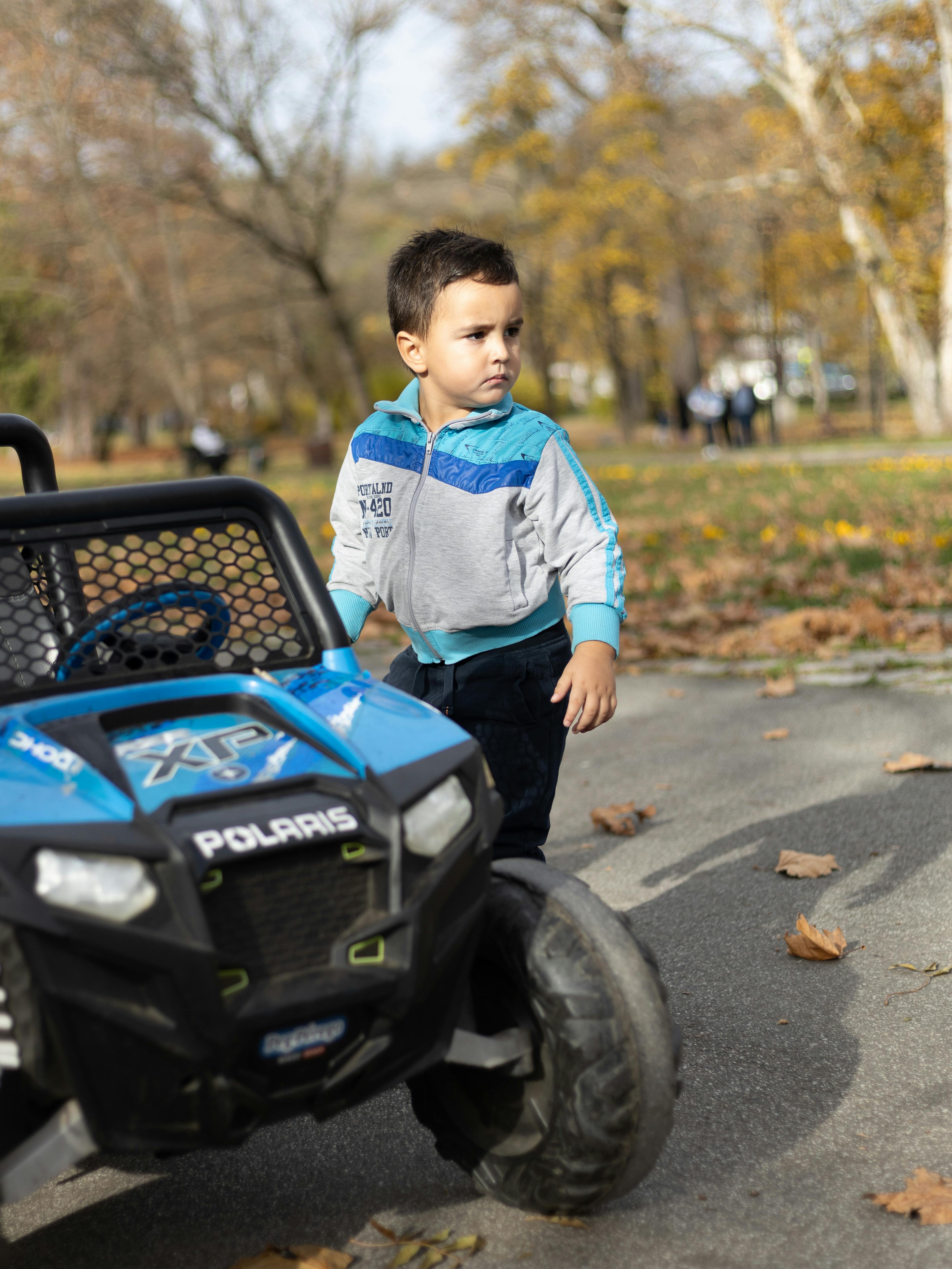 Little Boy Next to a Toy Car · Free Stock Photo
