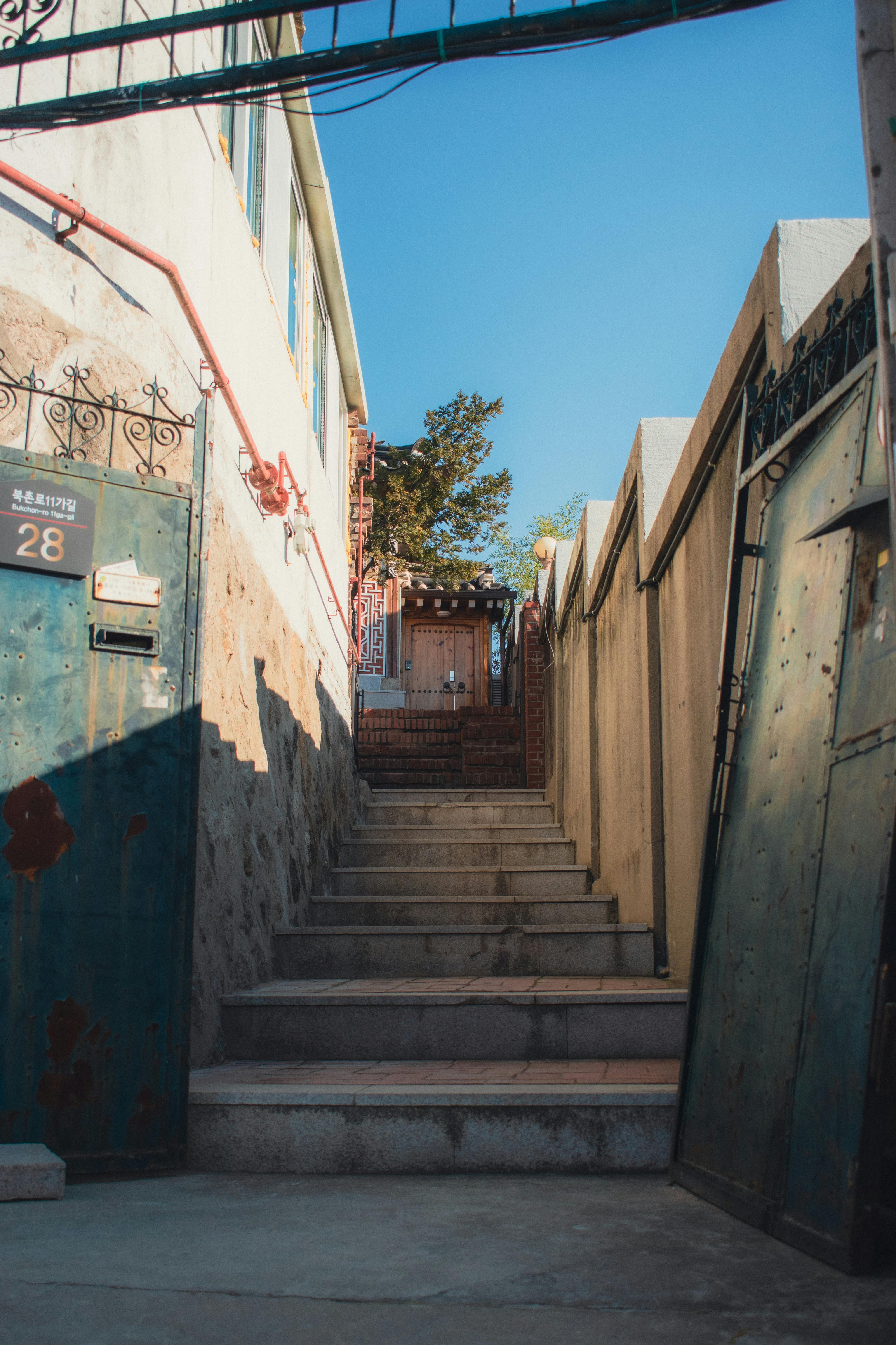 A narrow alleyway with steps leading up to a door · Free Stock Photo