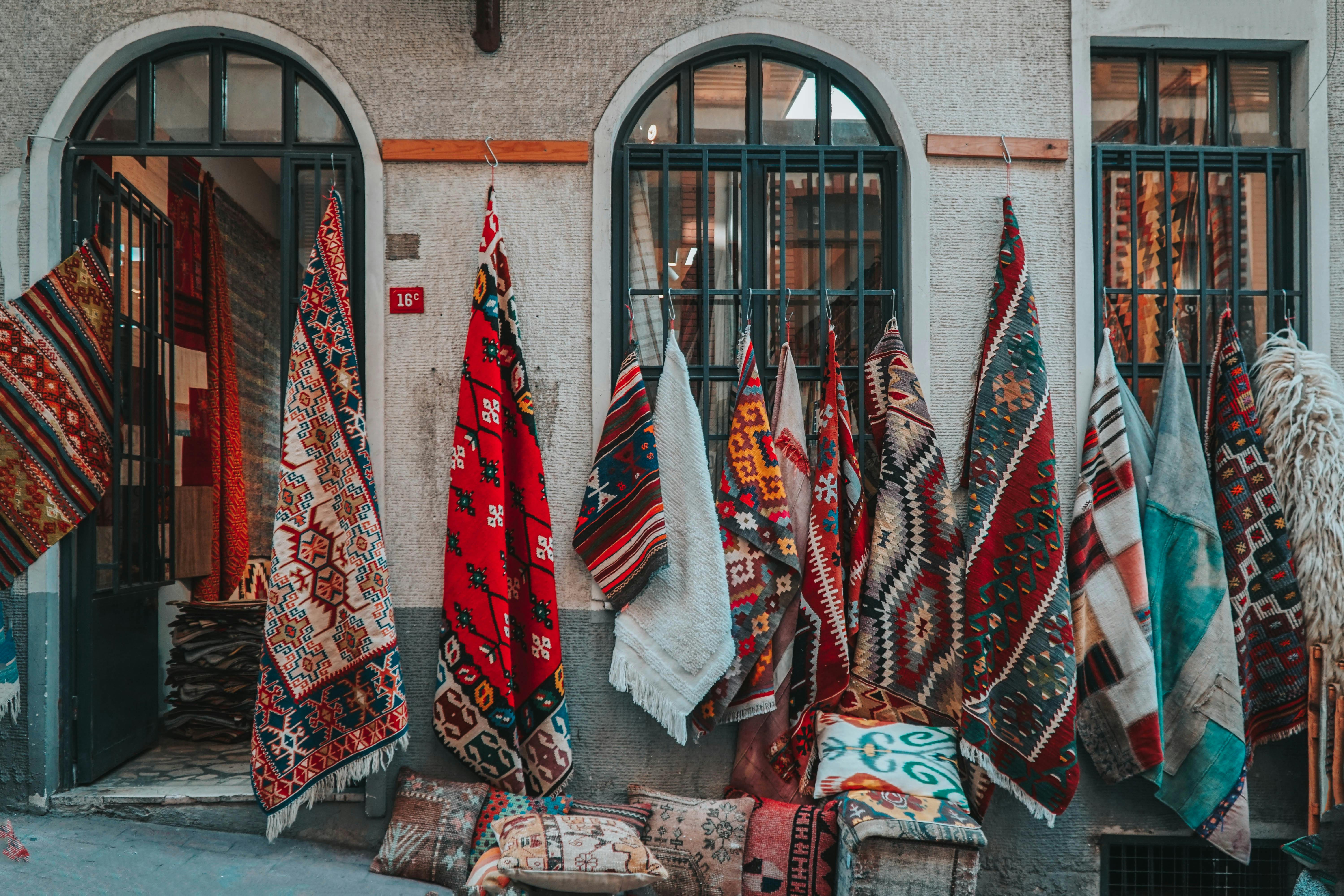 Traditional Carpets near Building Wall · Free Stock Photo