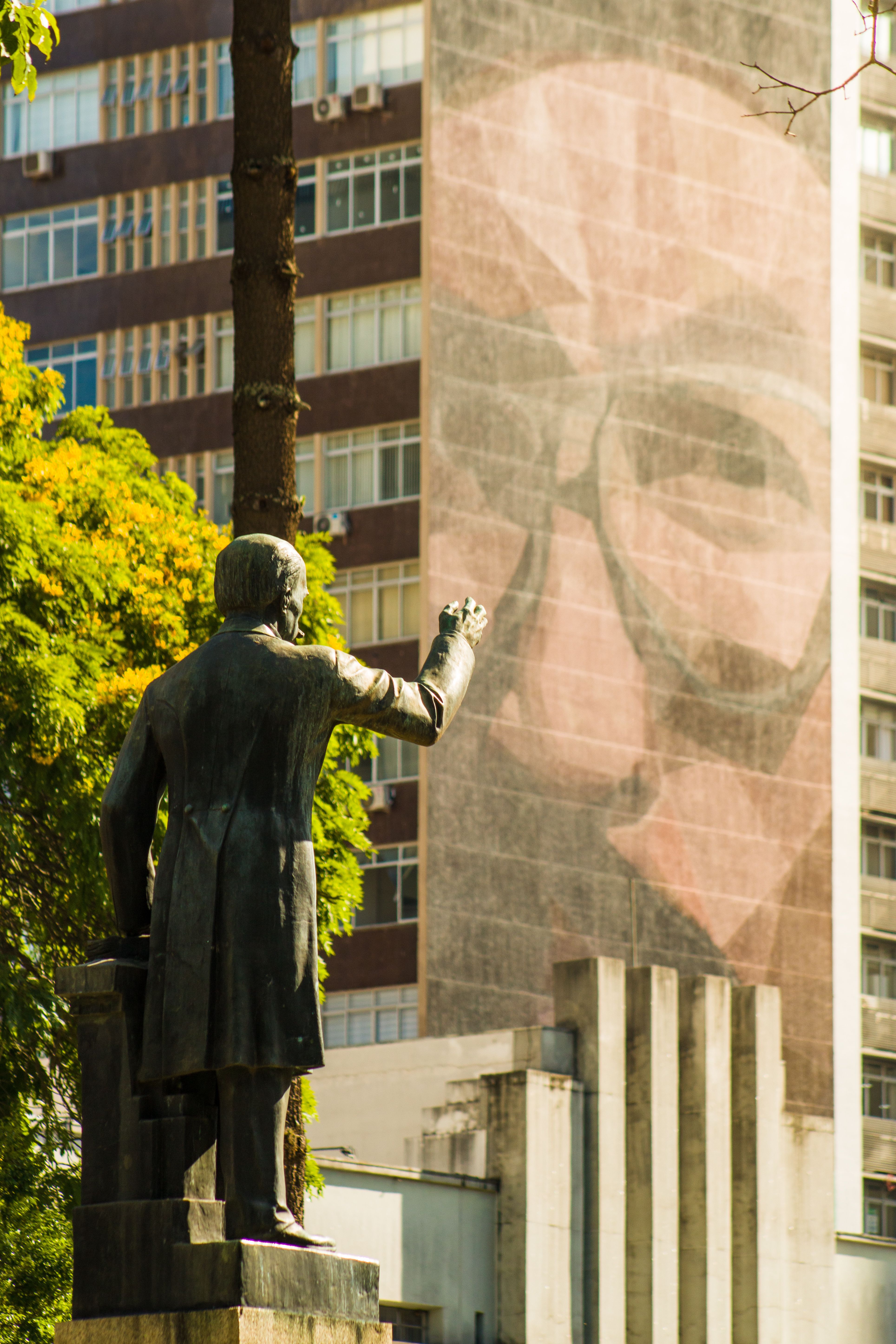 Statue of a Man with a Mural in the Background · Free Stock Photo