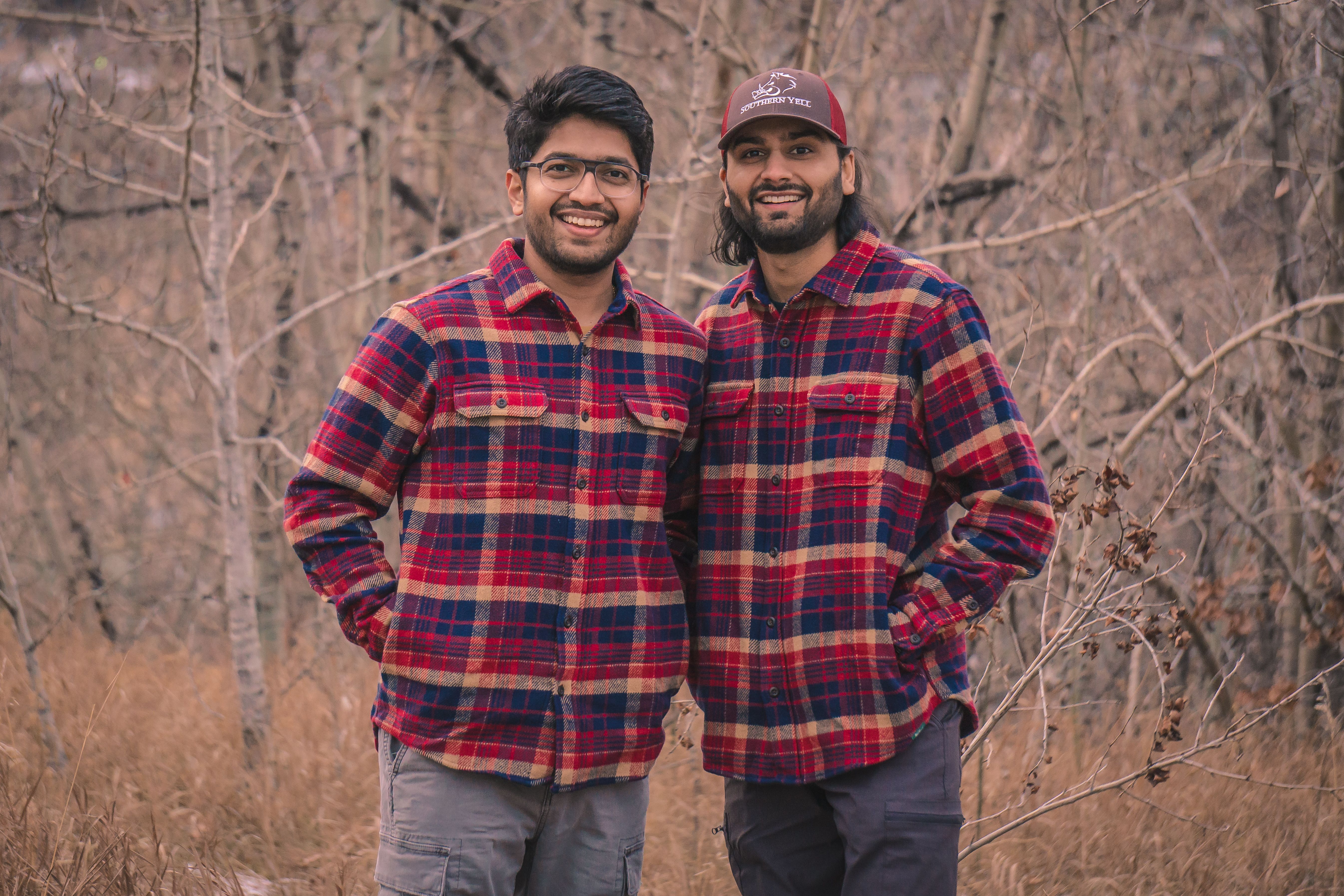 Two Young Men in Red Plaid Shirts Posing Together · Free Stock Photo