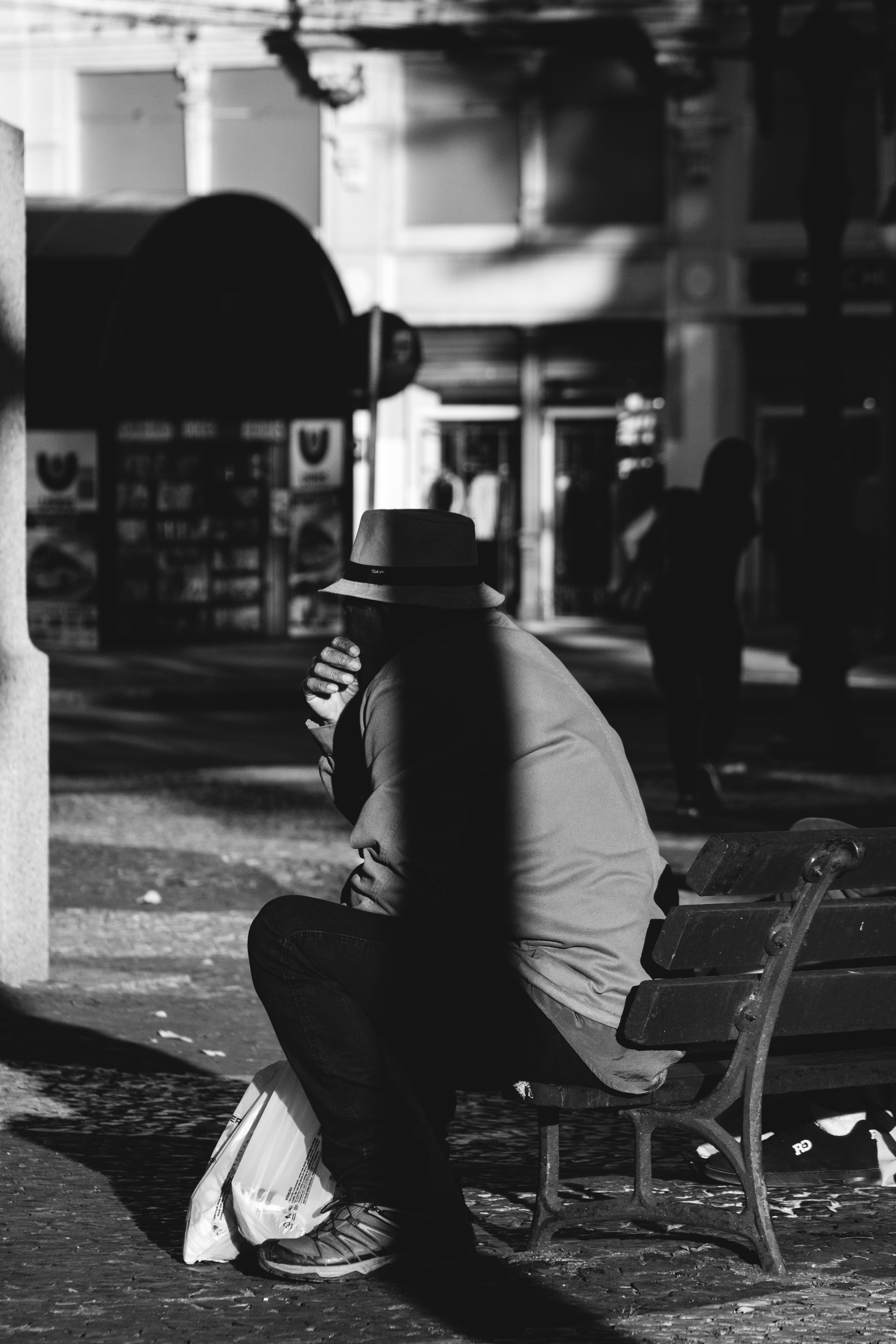 Man in Hat Sitting on Bench in Black and White · Free Stock Photo