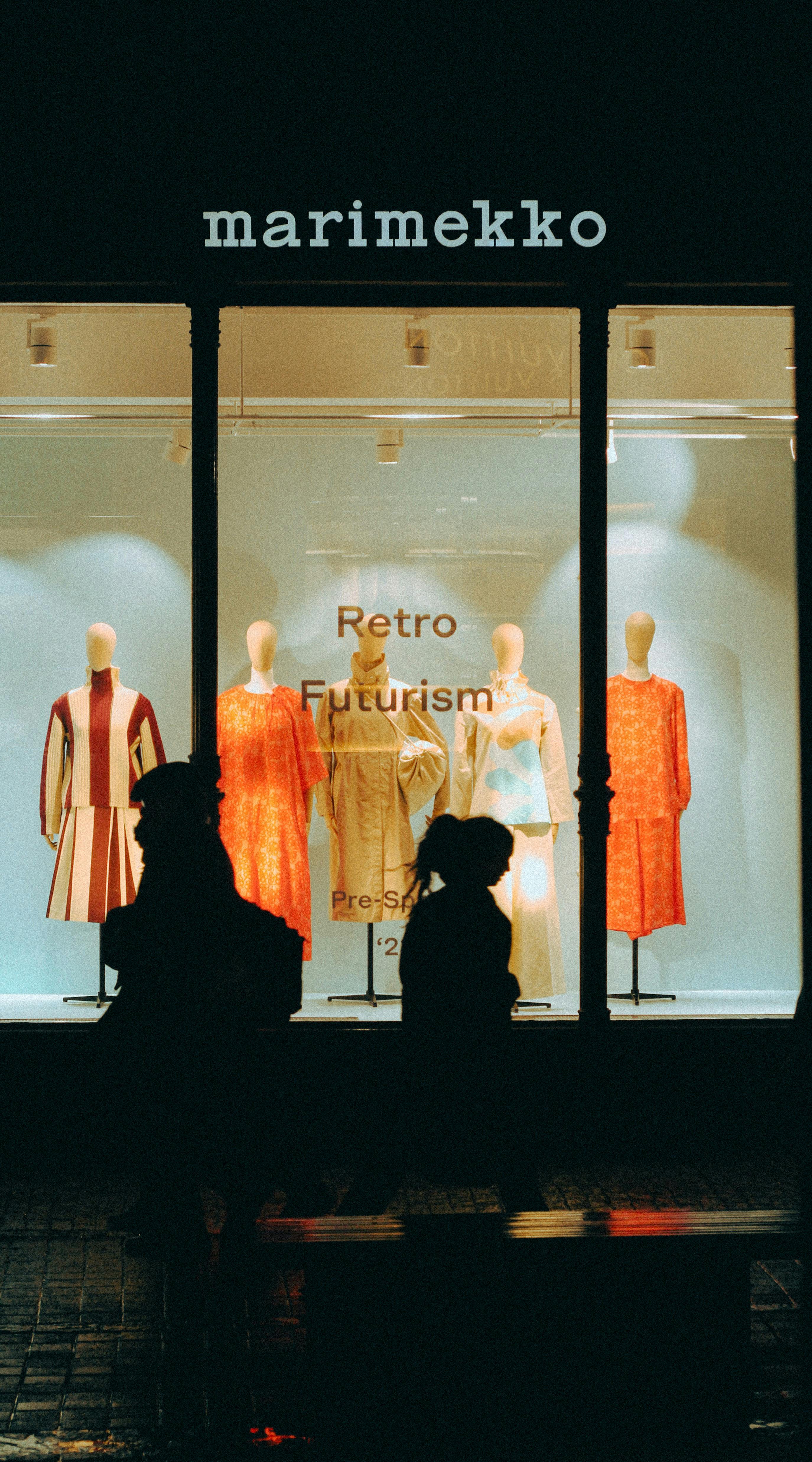 People Walking by Clothes Store Windows at Night · Free Stock Photo