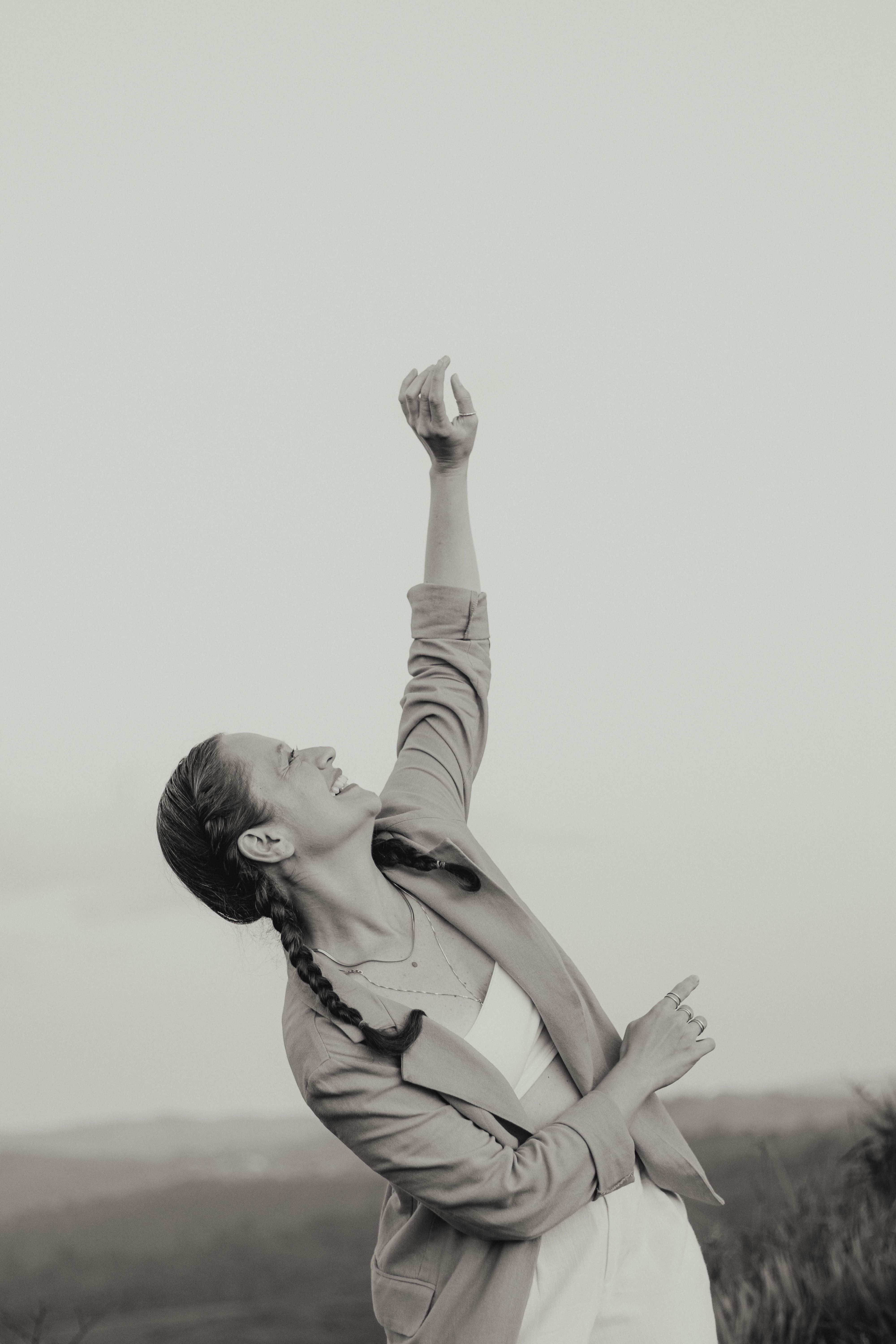 Smiling Woman with Raised Hand in a Glade · Free Stock Photo
