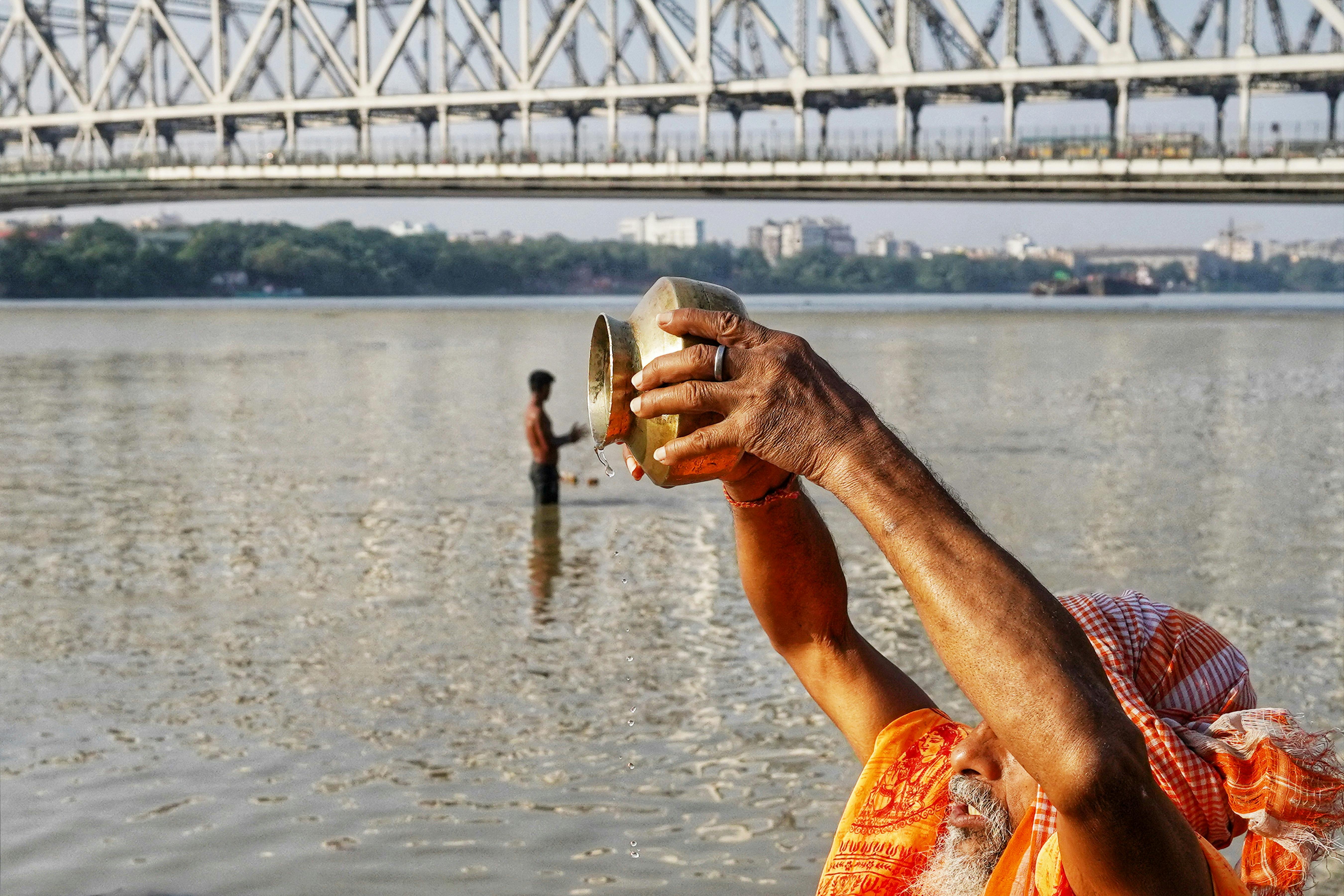 Man Pouring Water from a Brass Vessel While Standing in the River ...
