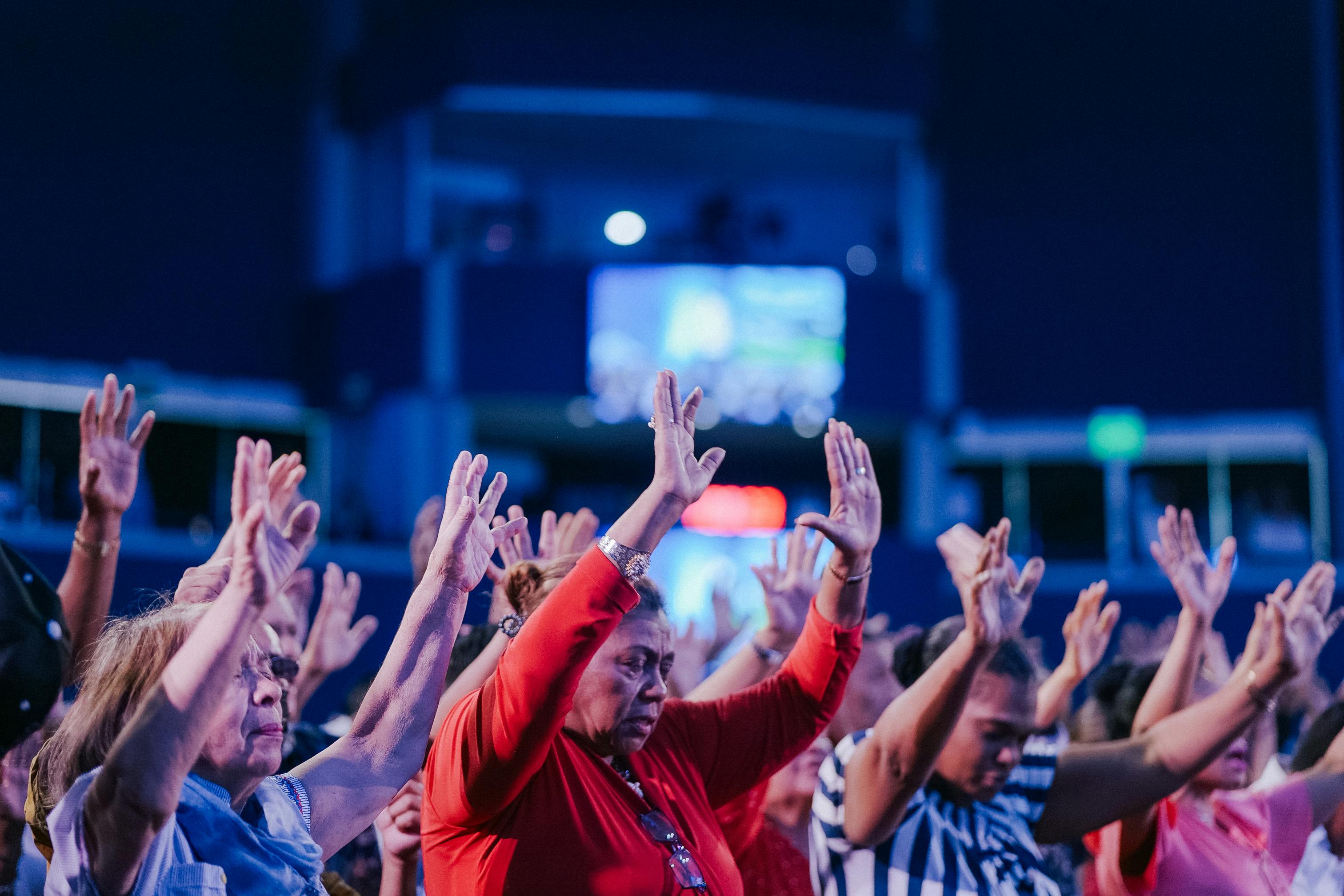 People in a church raising their hands · Free Stock Photo