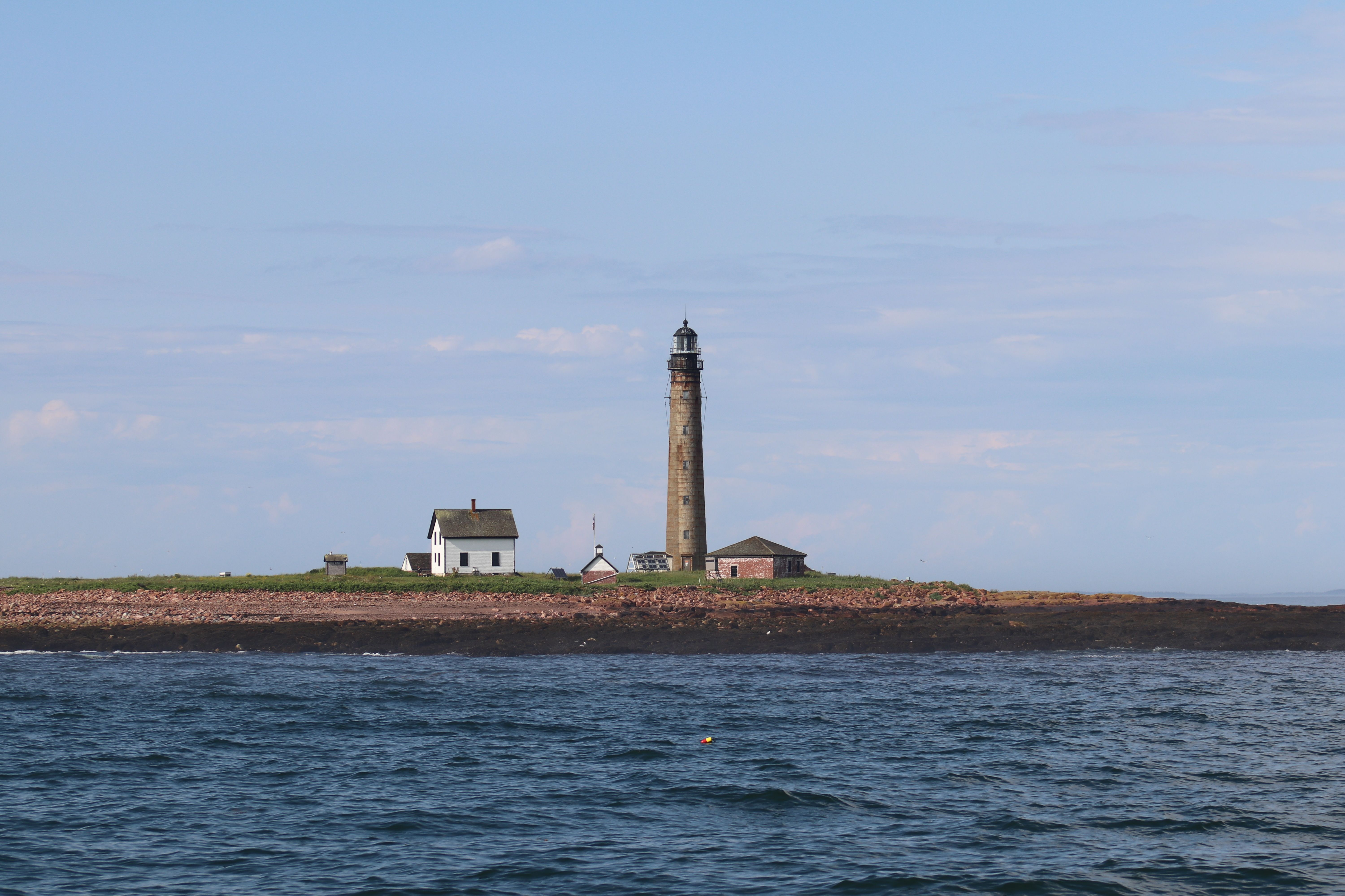 Coast with a Small House and a Lighthouse · Free Stock Photo