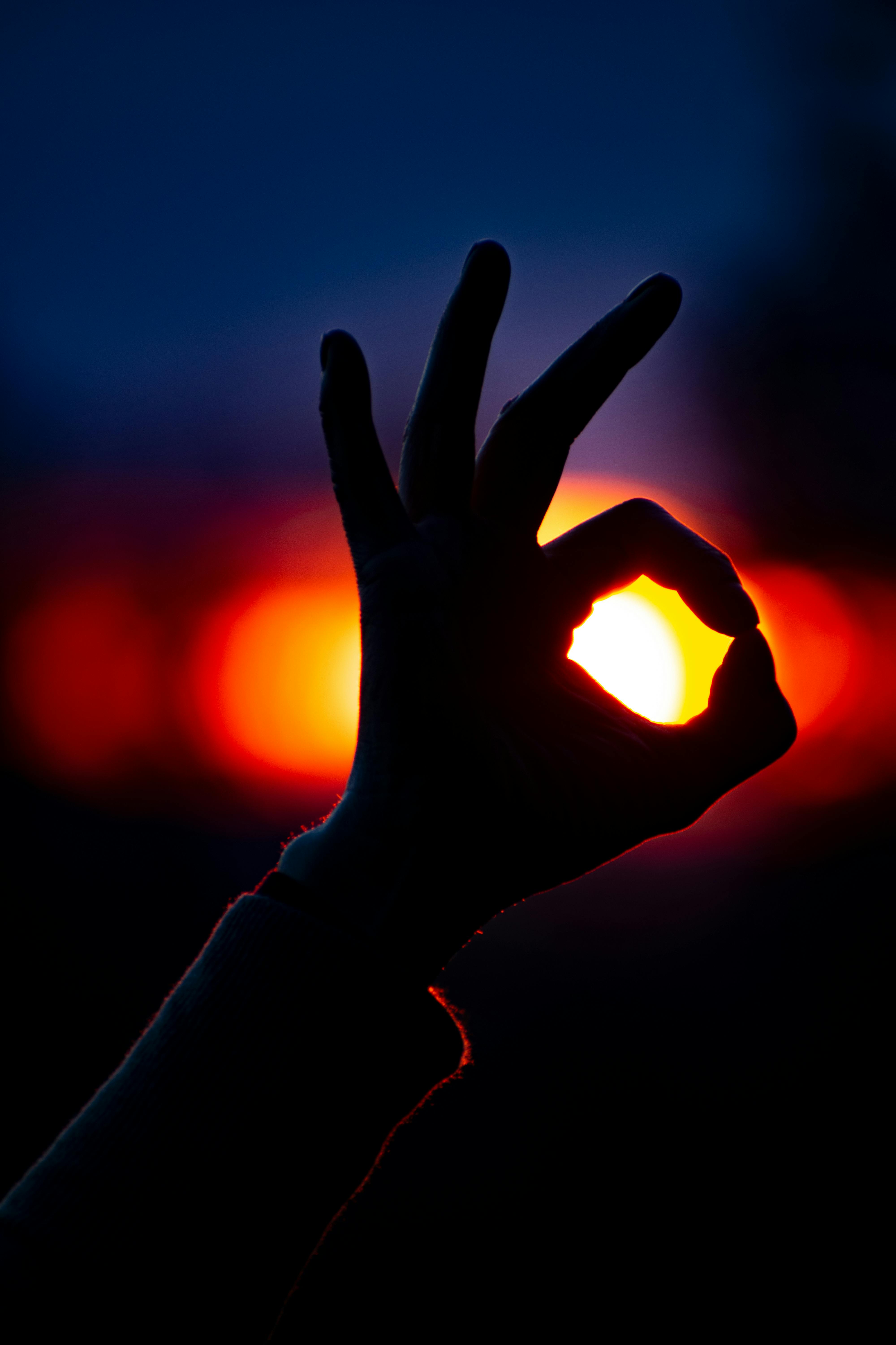 Crop woman showing okay gesture touching sun on street · Free Stock Photo