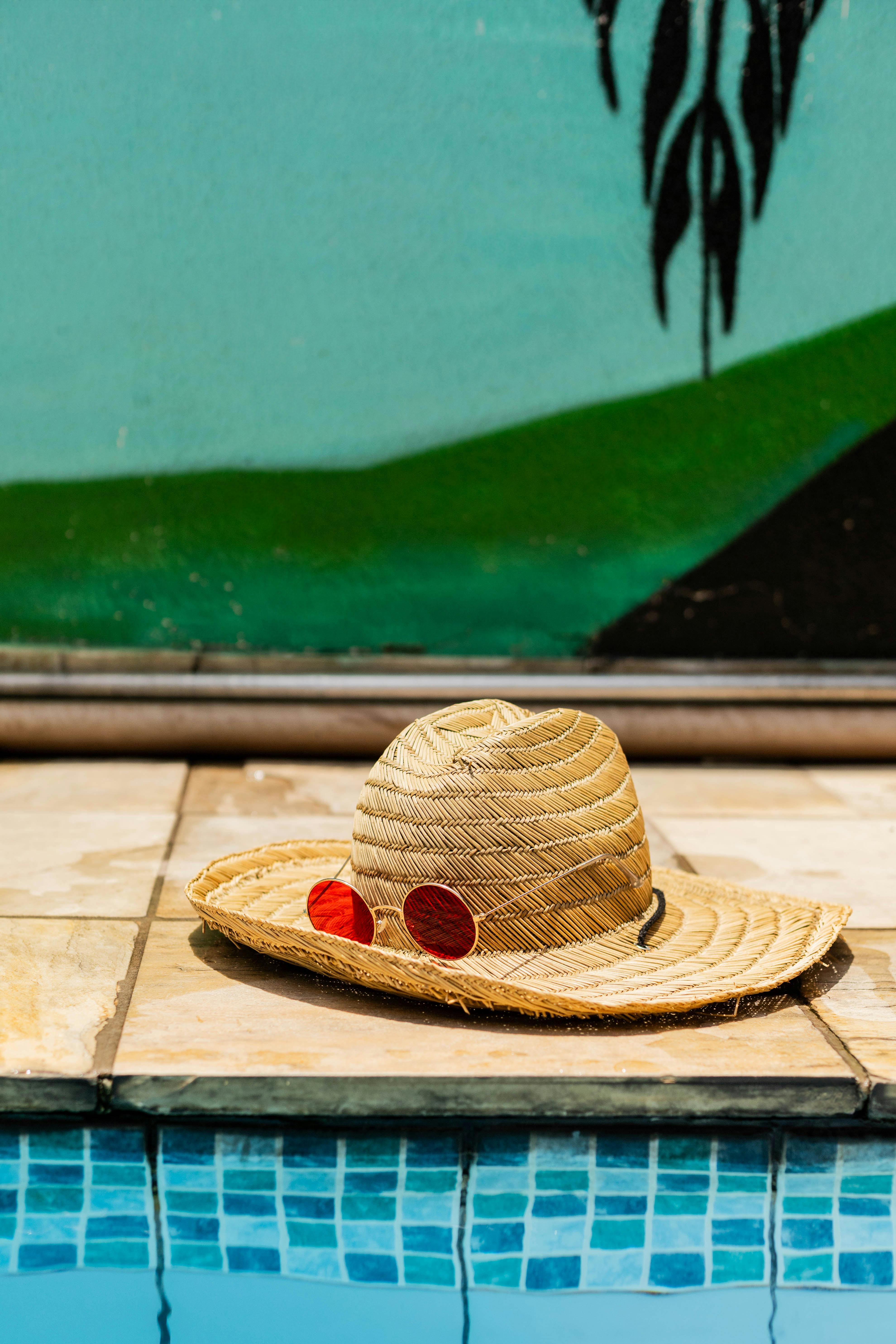 Beige And Black Hat Near Swimming Pool · Free Stock Photo