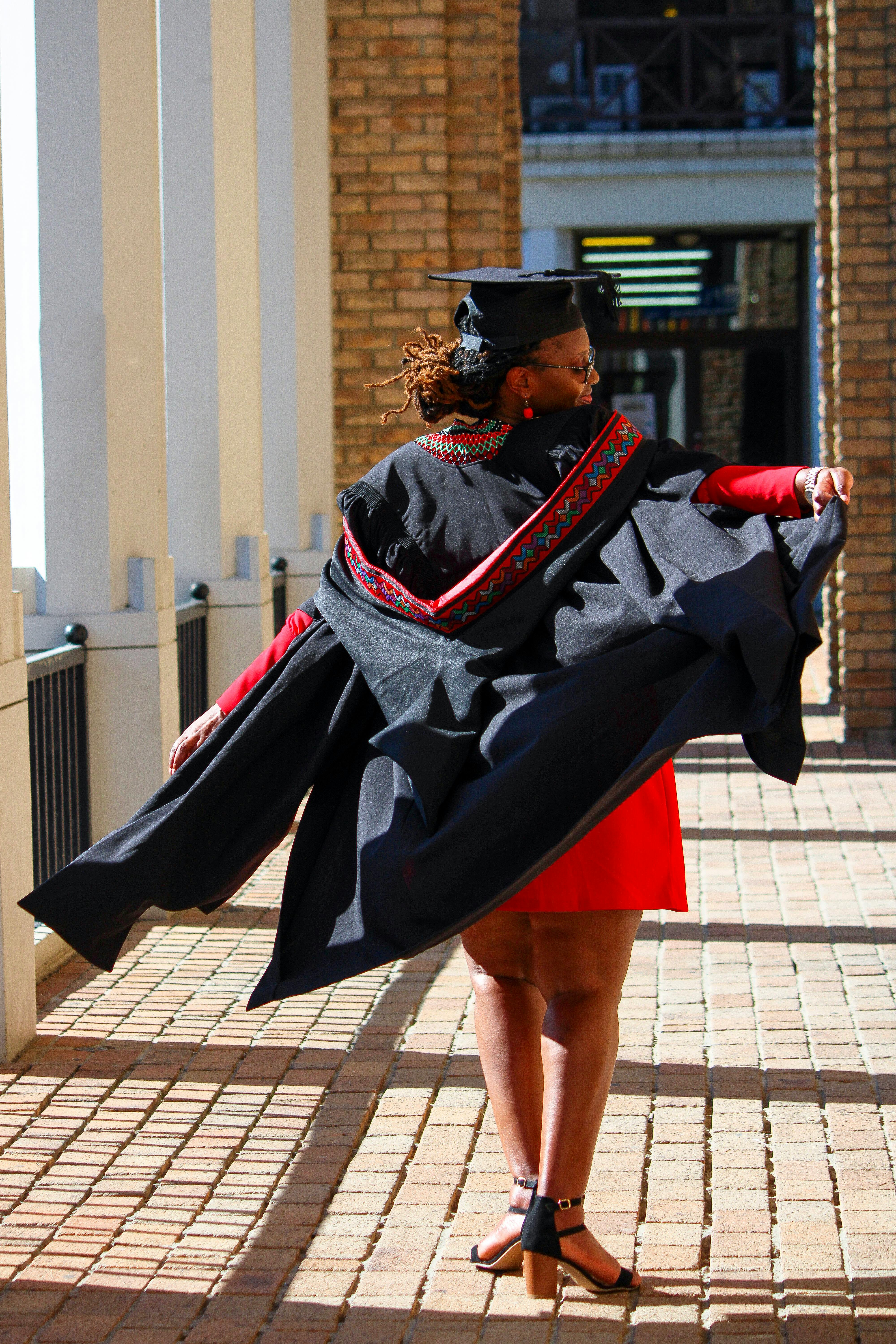 Woman Walking on Pavement During Graduation Day · Free Stock Photo