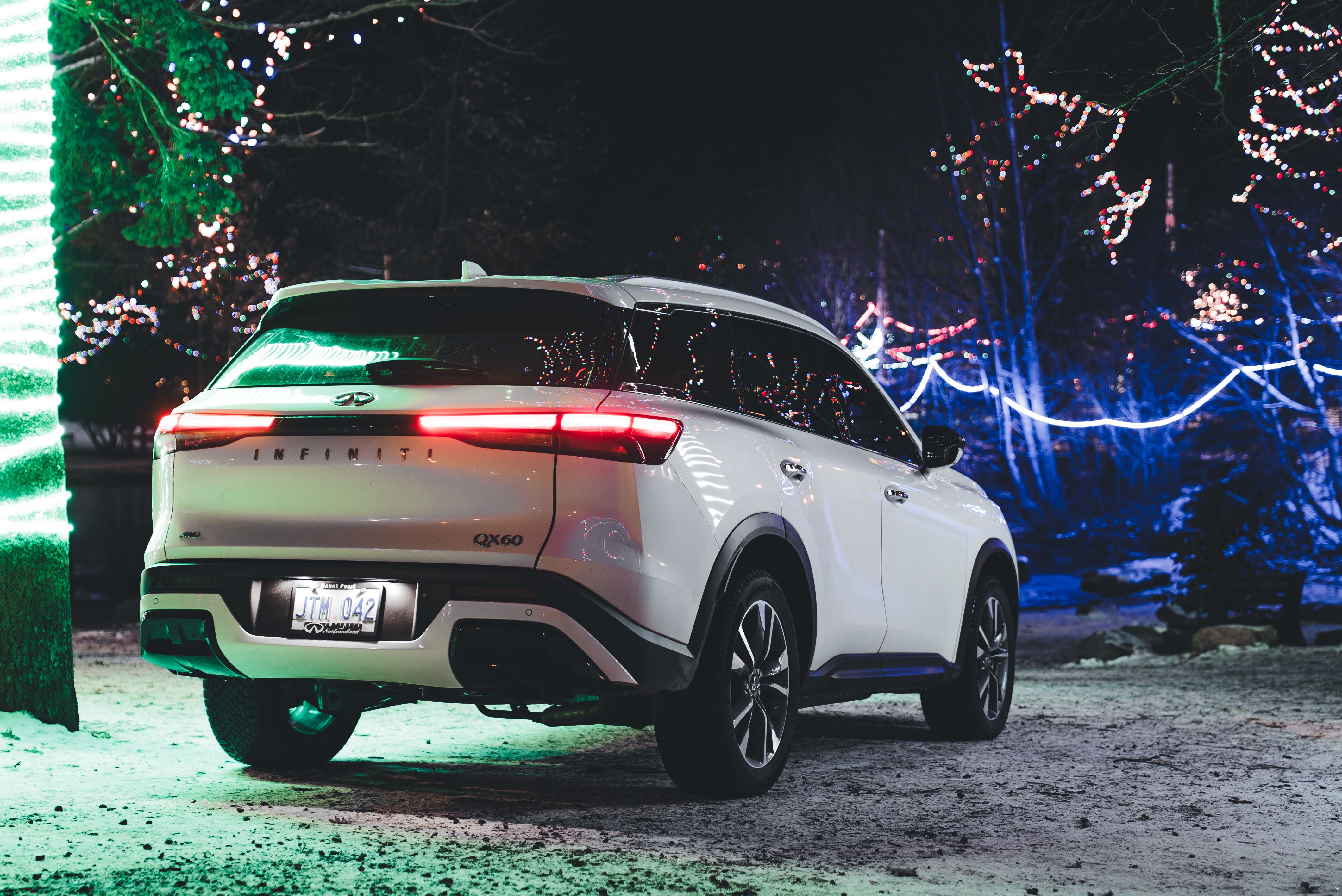 White SUV Car with Christmas Lights in the Background · Free Stock Photo