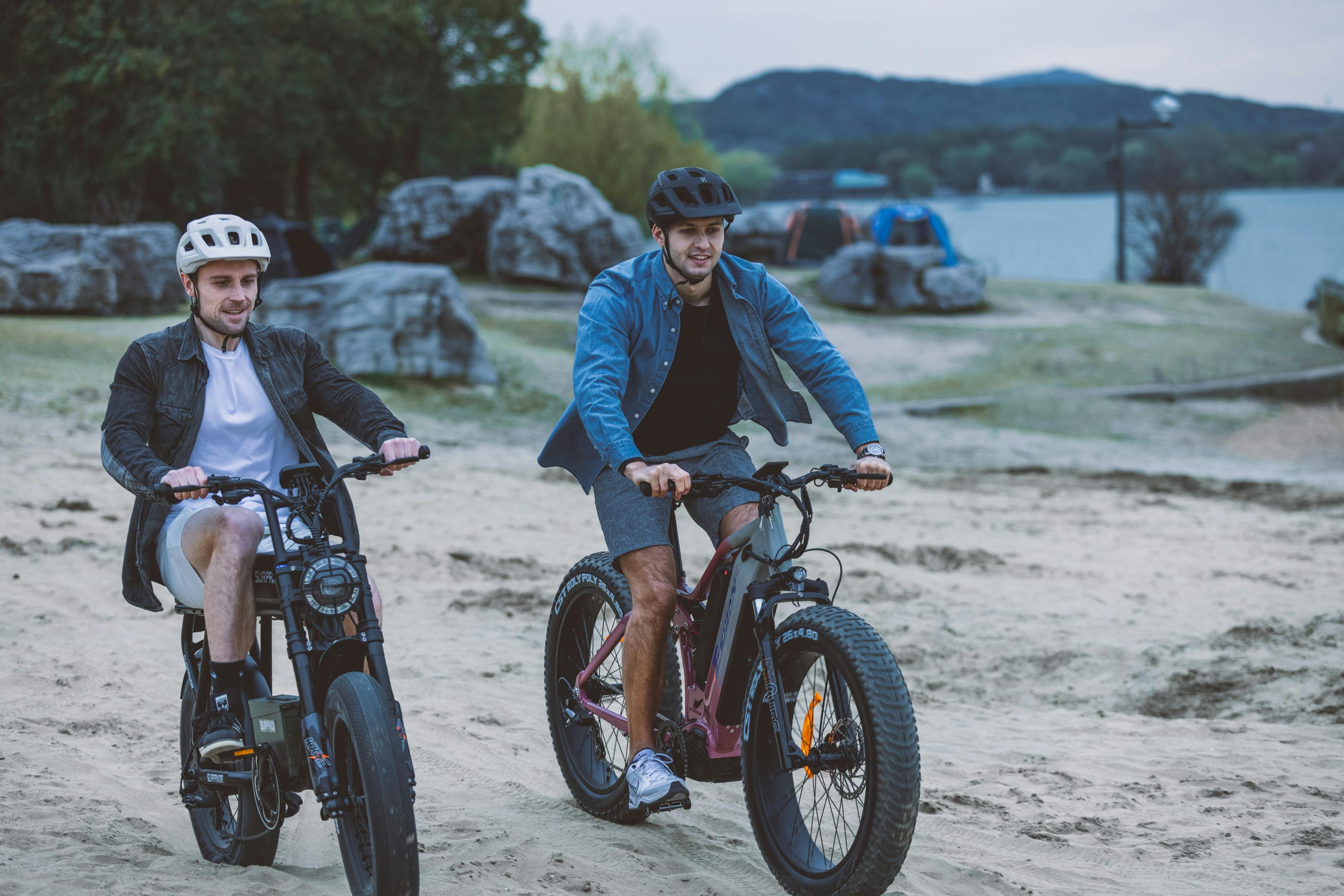 Two Young Men Riding Electric Bikes on Sand · Free Stock Photo