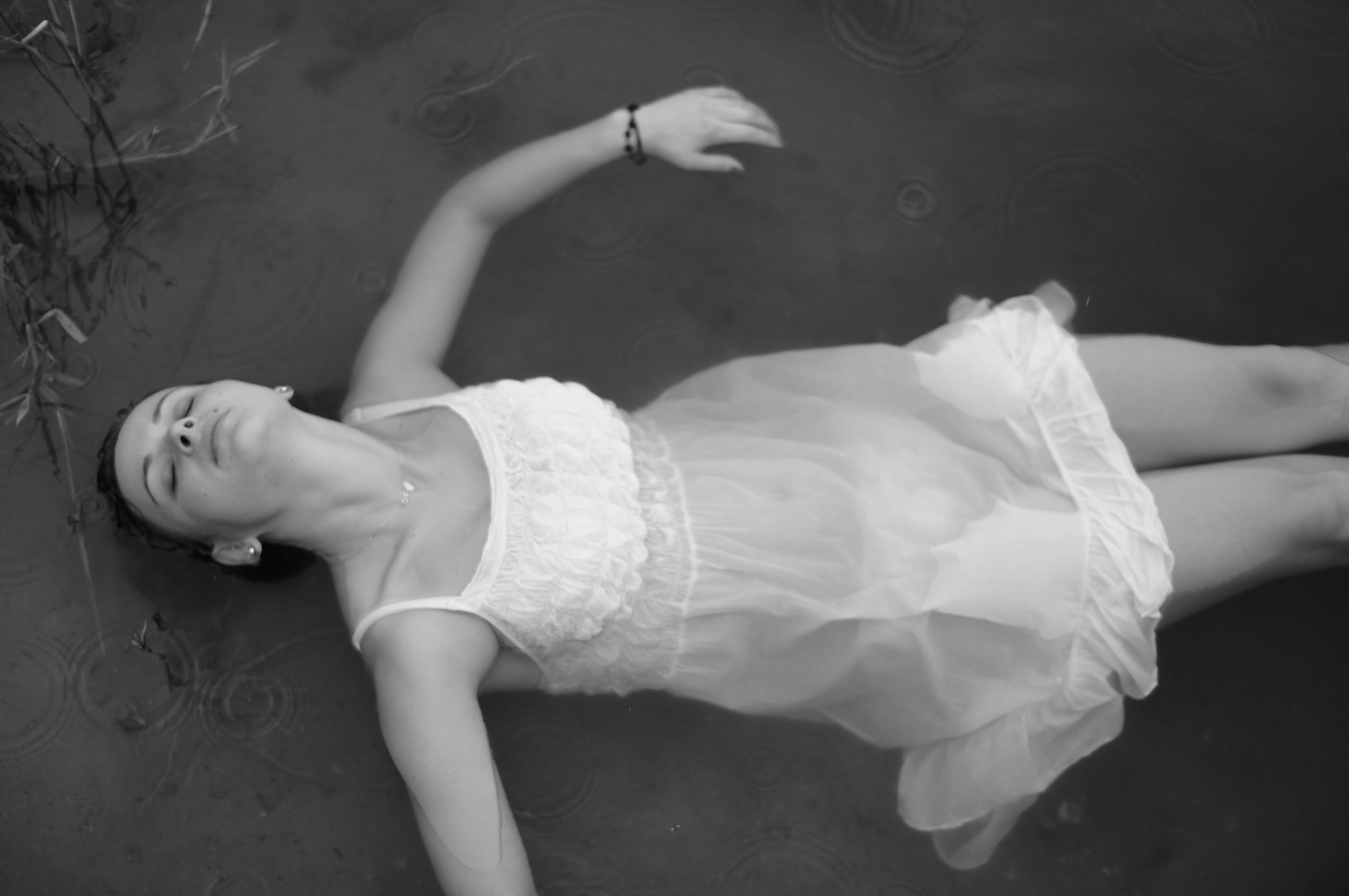 A woman in a white dress floating in the water · Free Stock Photo