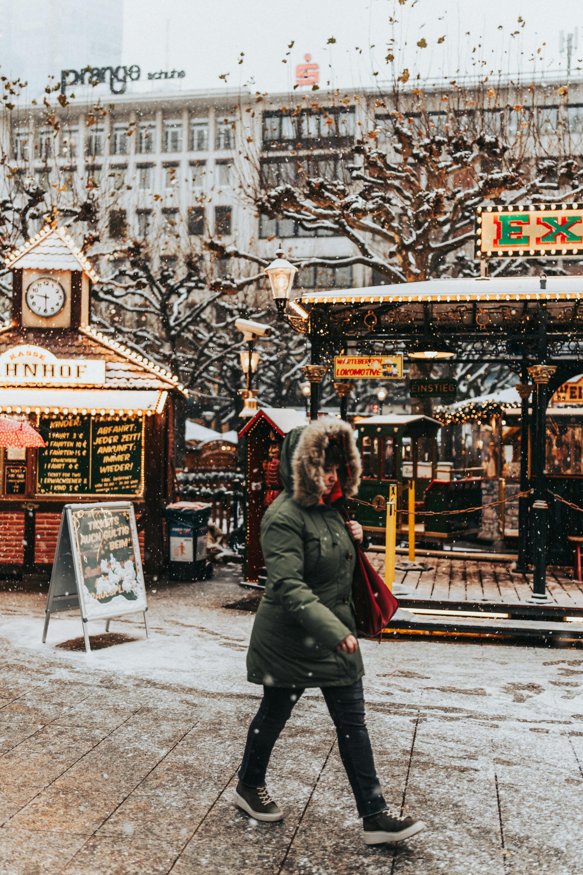 Woman Walking Among Booths on a Christmas Market · Free Stock Photo