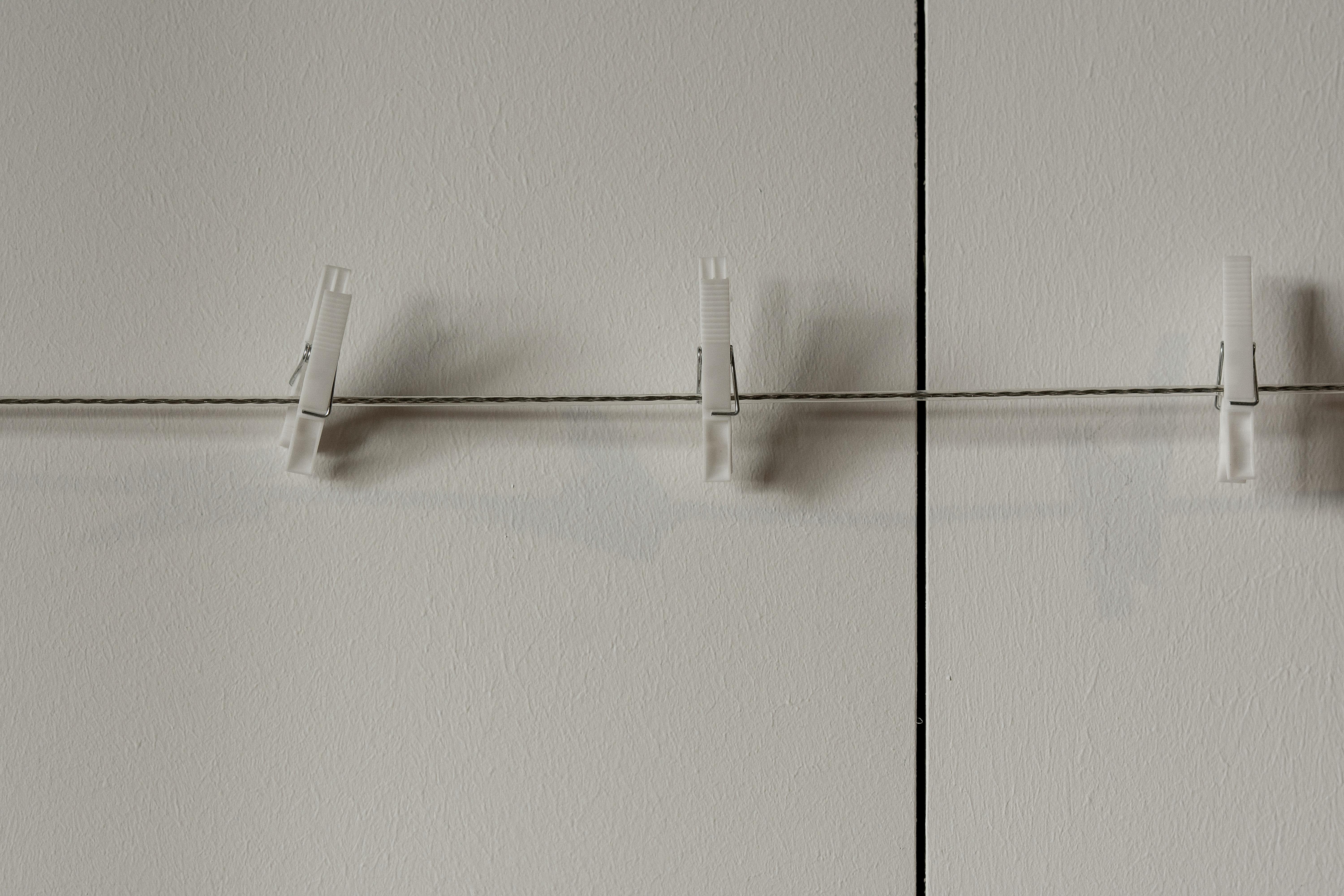 White Clips on a White Clothesline · Free Stock Photo